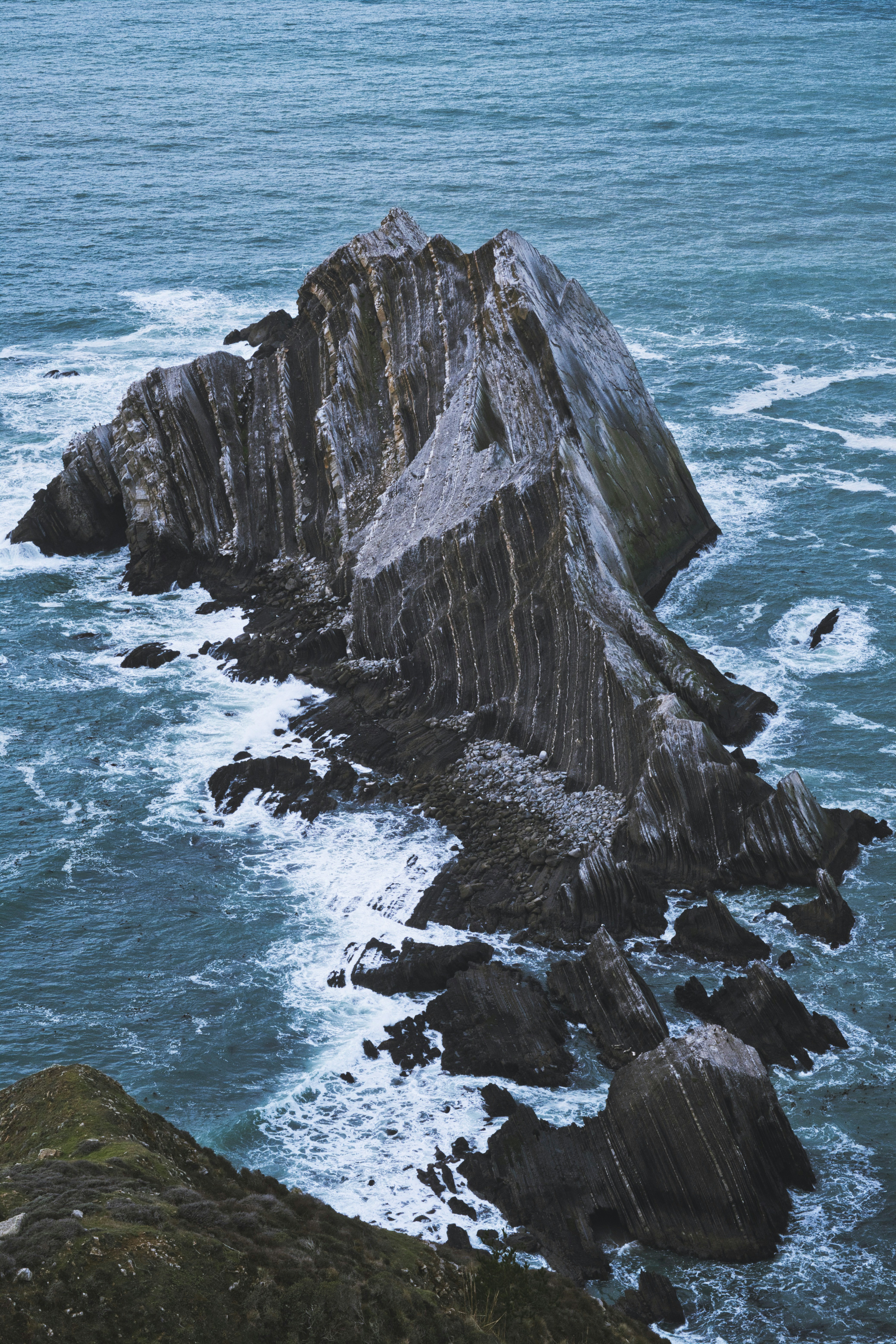 Black and gray rock formation beside body of water during daytime photo ...