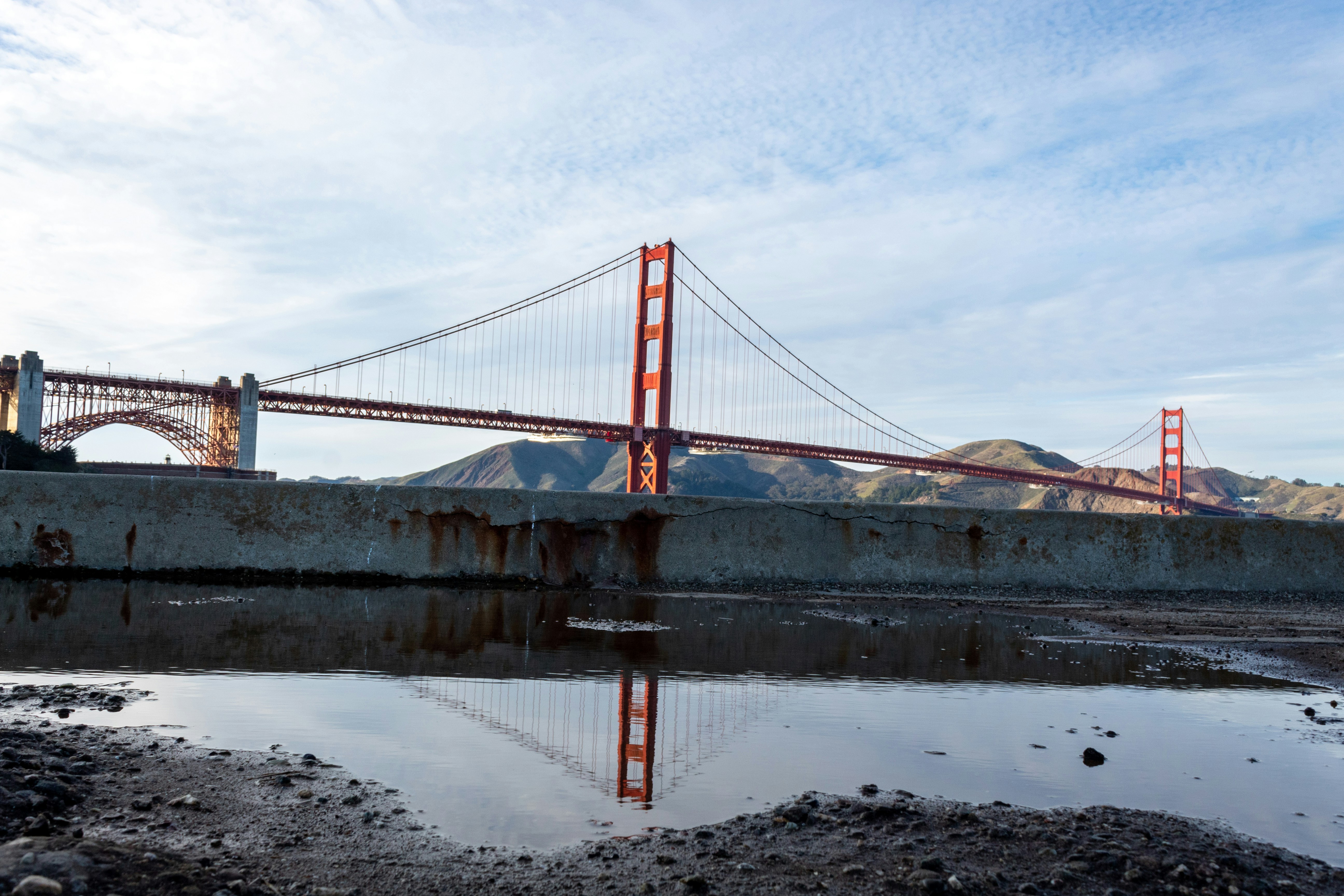 Red Span Over Calm Waters: The Golden Gate Reflects in a Quiet Shore Pool