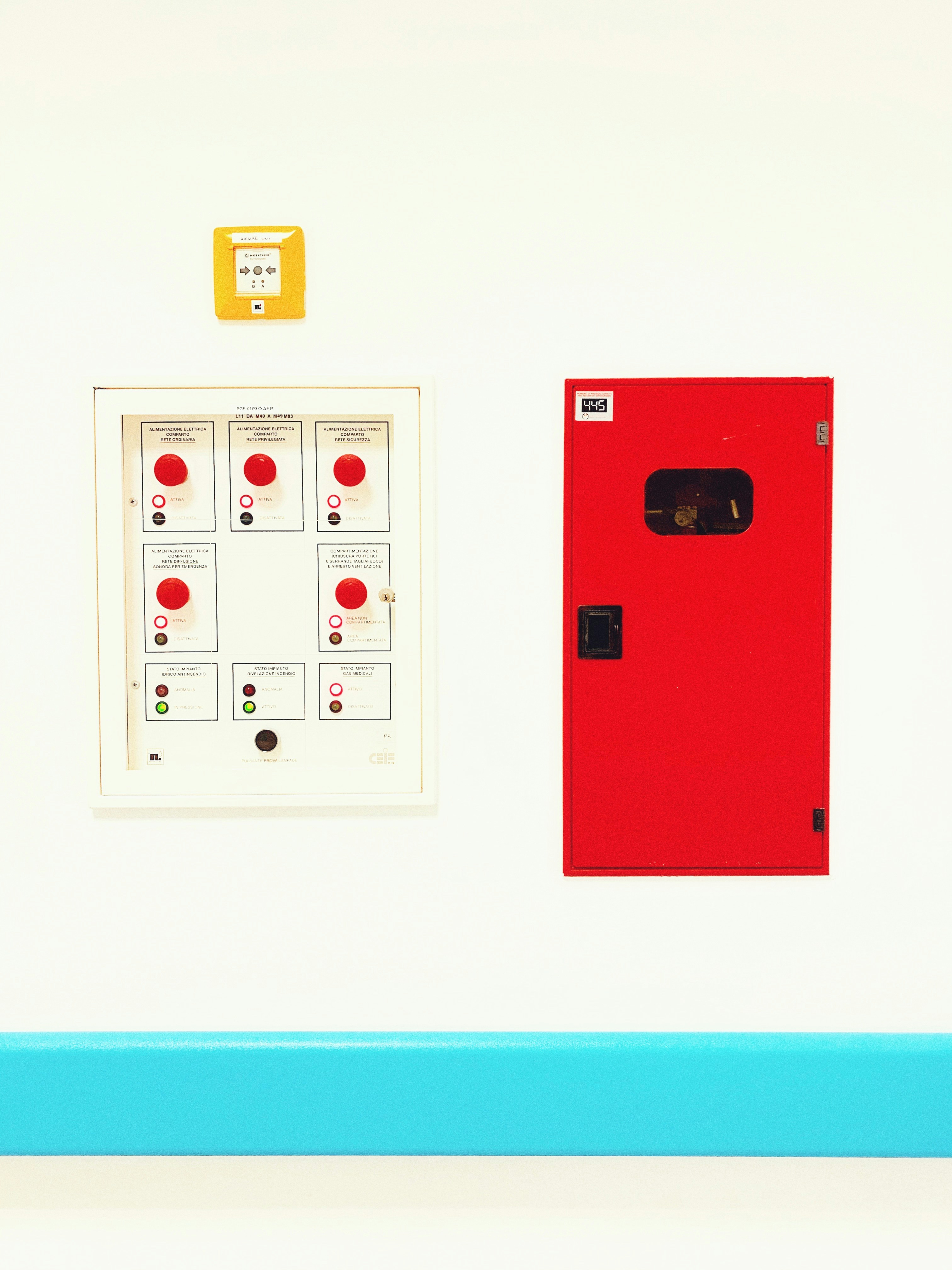 Crimson Emergency Cabinet Framed by a Quiet White Wall