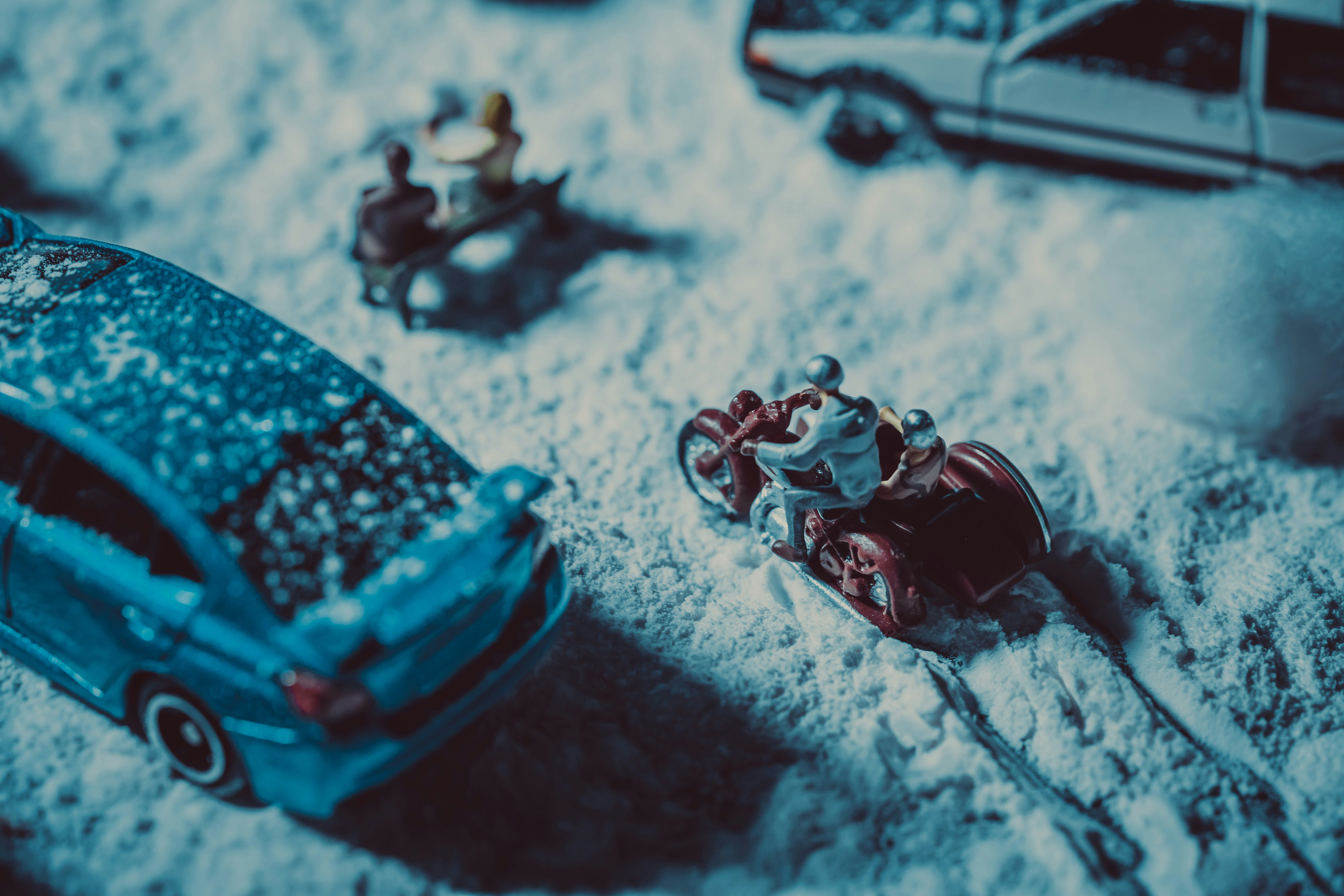 Miniature Winter Chase: Snow-Covered Cars and Riders