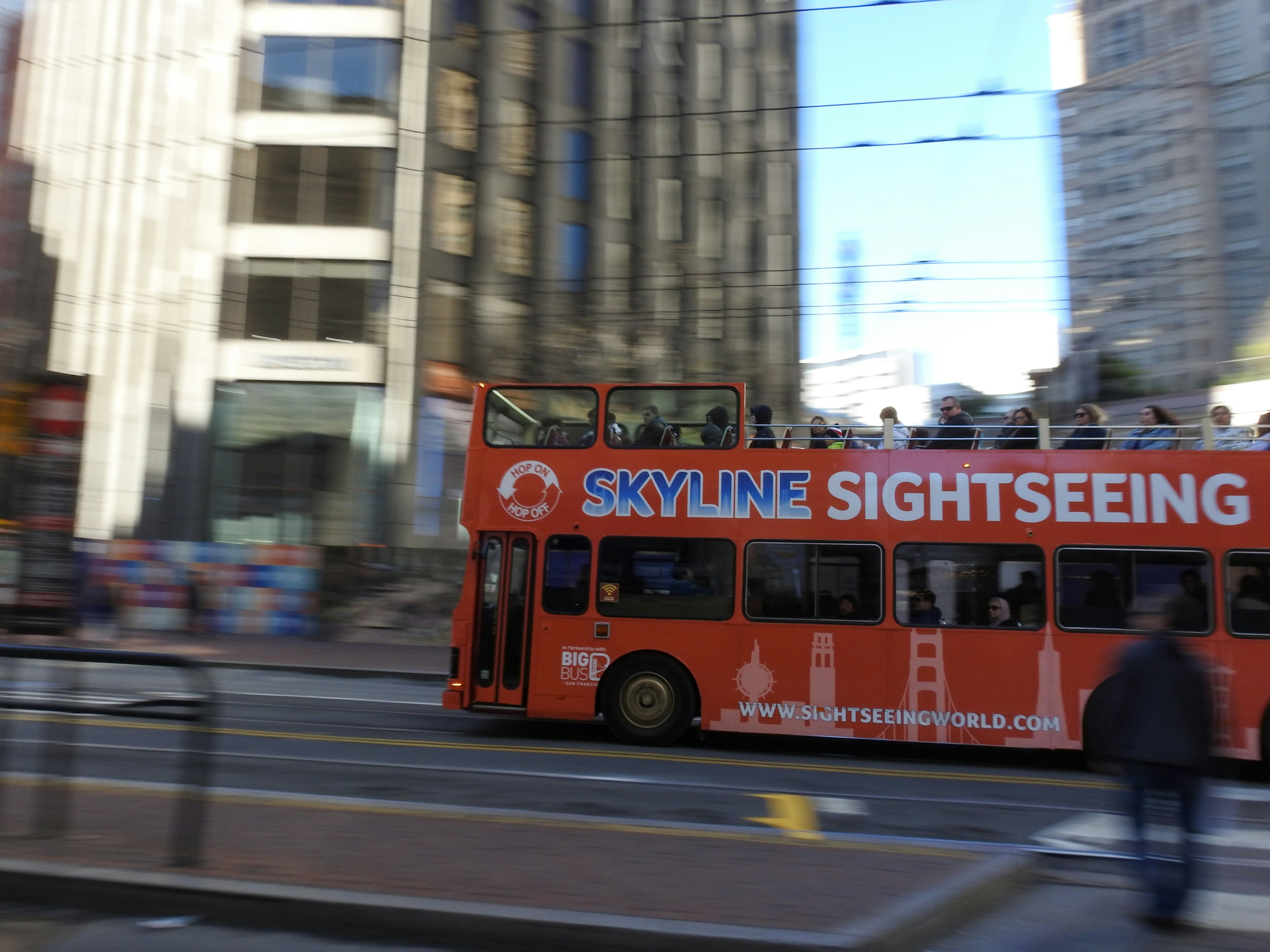 Red Skyline Sightseeing Bus Slicing Through Downtown Blur