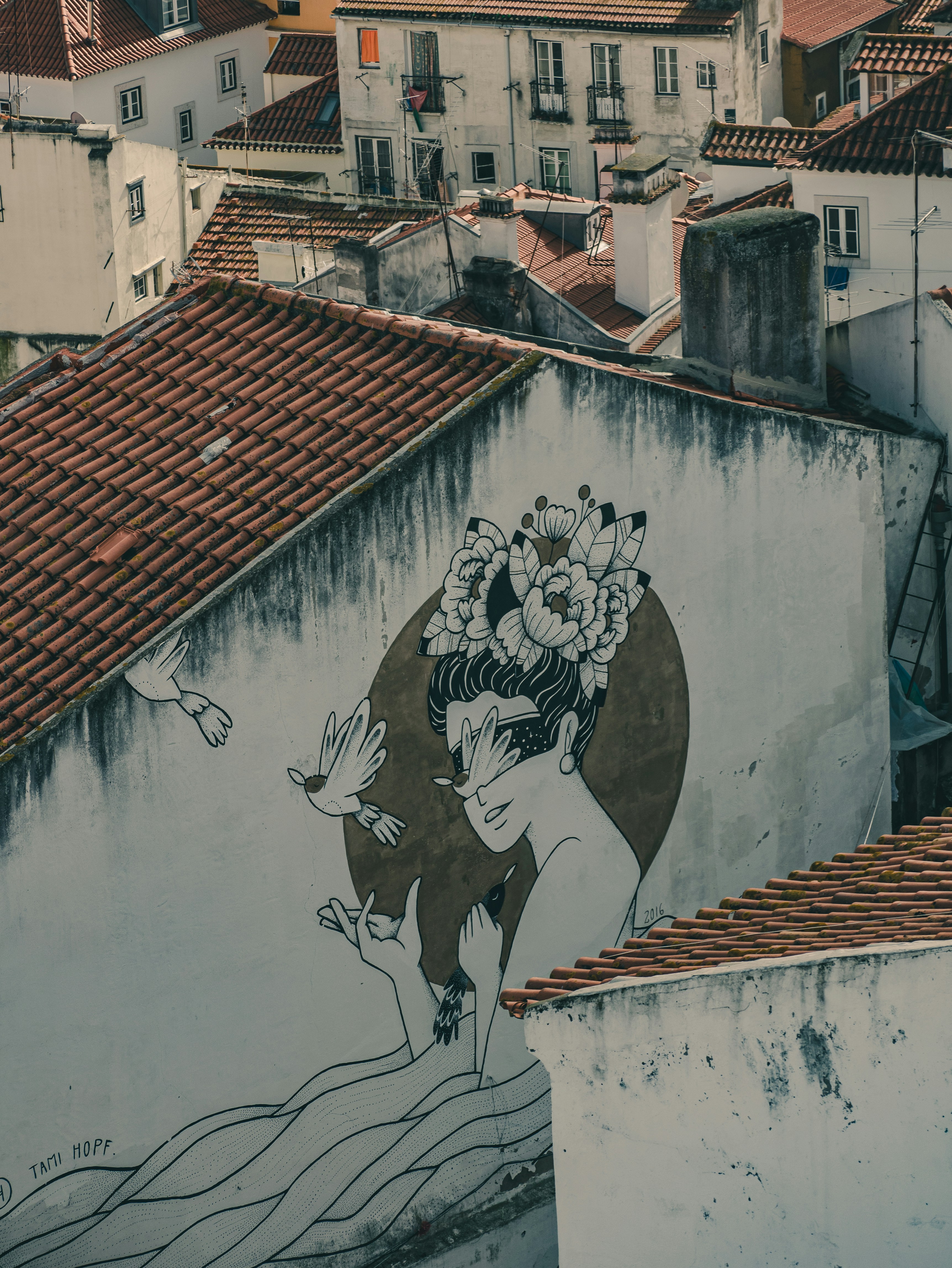 Mural Maiden Amid Red Tile Rooftops