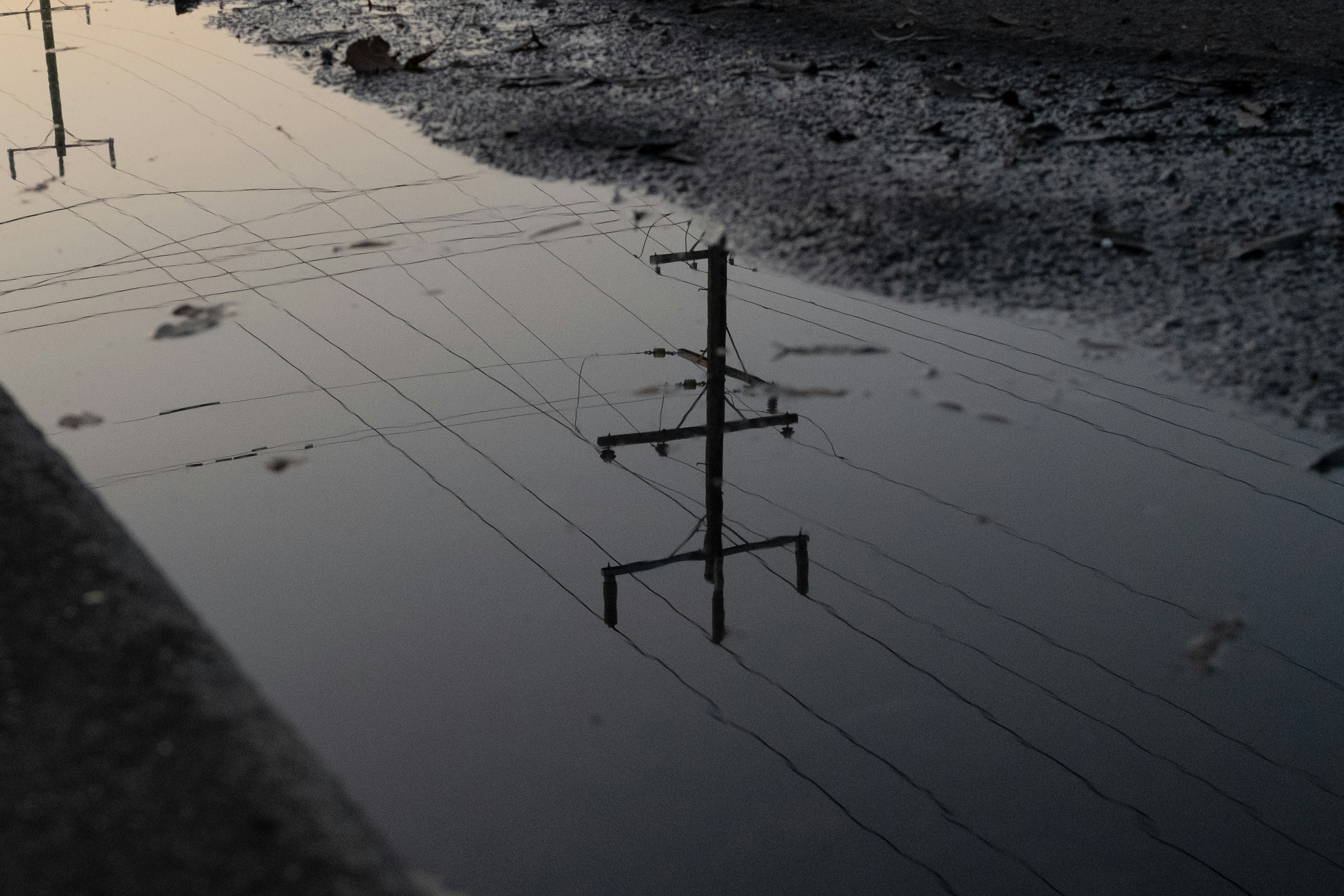 Urban Reflection: Power Lines in Puddle