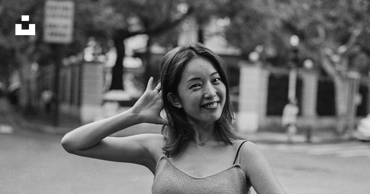 스파게티 스트랩 탑과 검은 치마를 입은 여성이 낮에 보도에 서 있습니다 사진 Unsplash의 무료 상하이 이미지