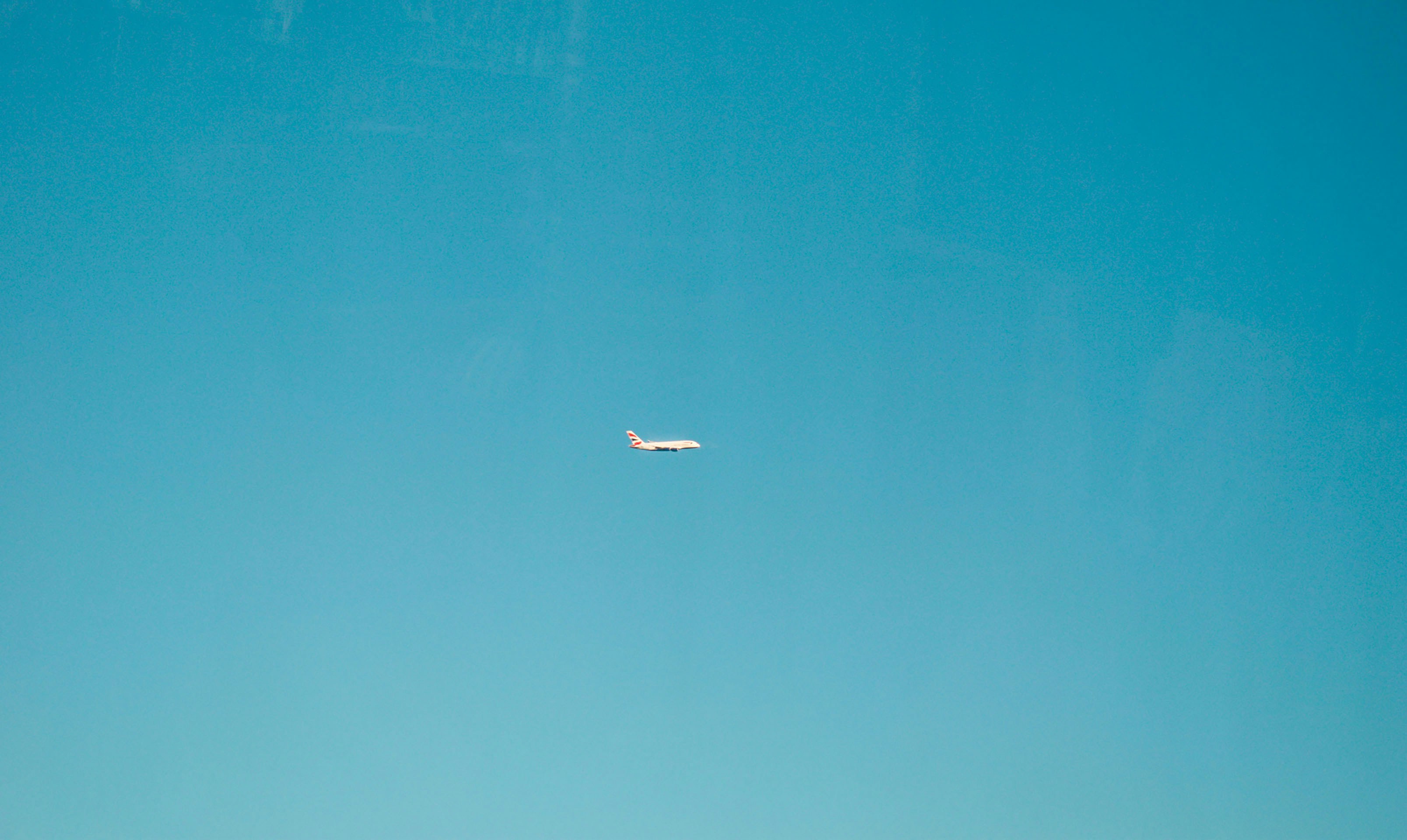 Tiny white jet in a vast blue sky