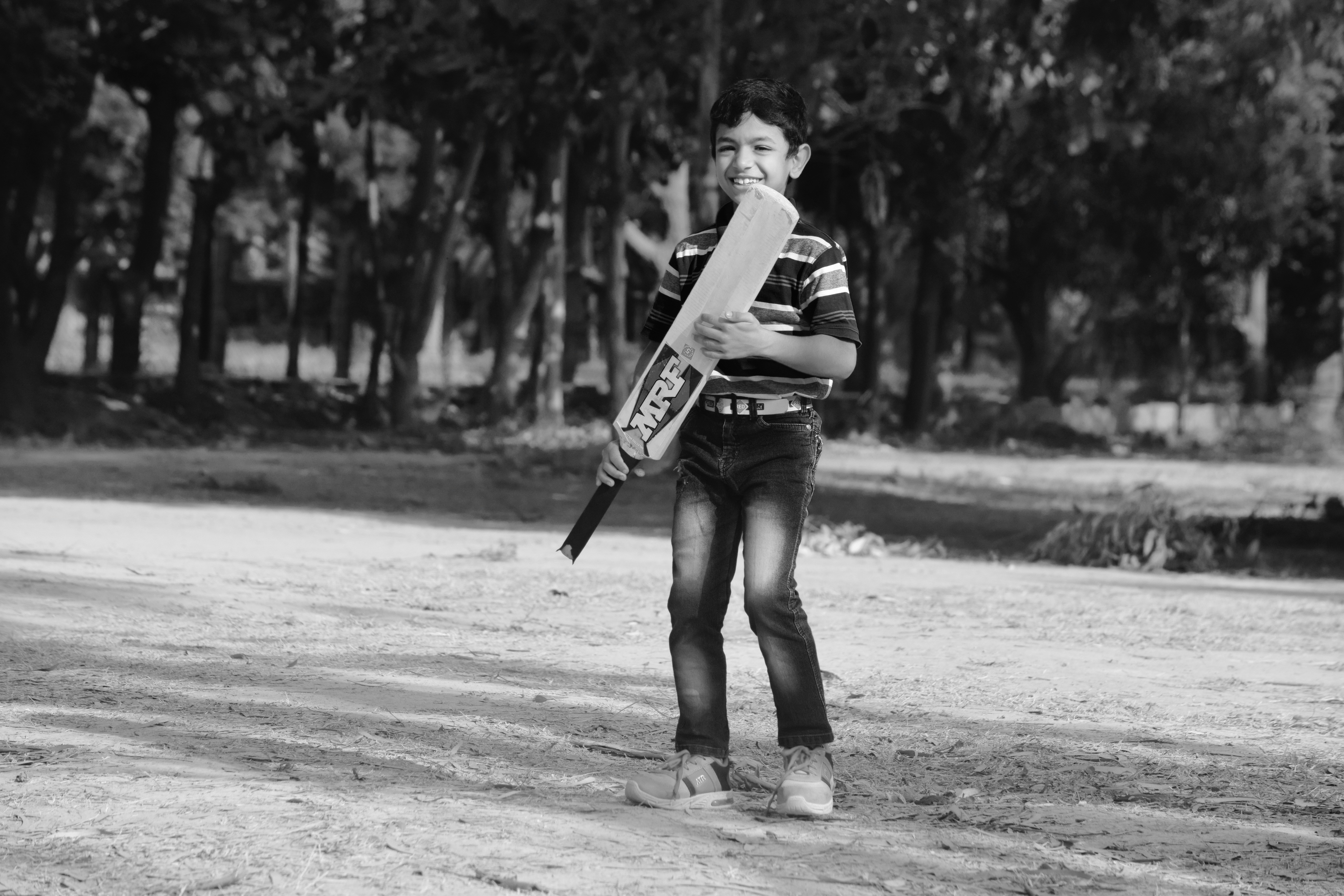 Boy with a cardboard rocket gathers sunlight on a sunlit clearing