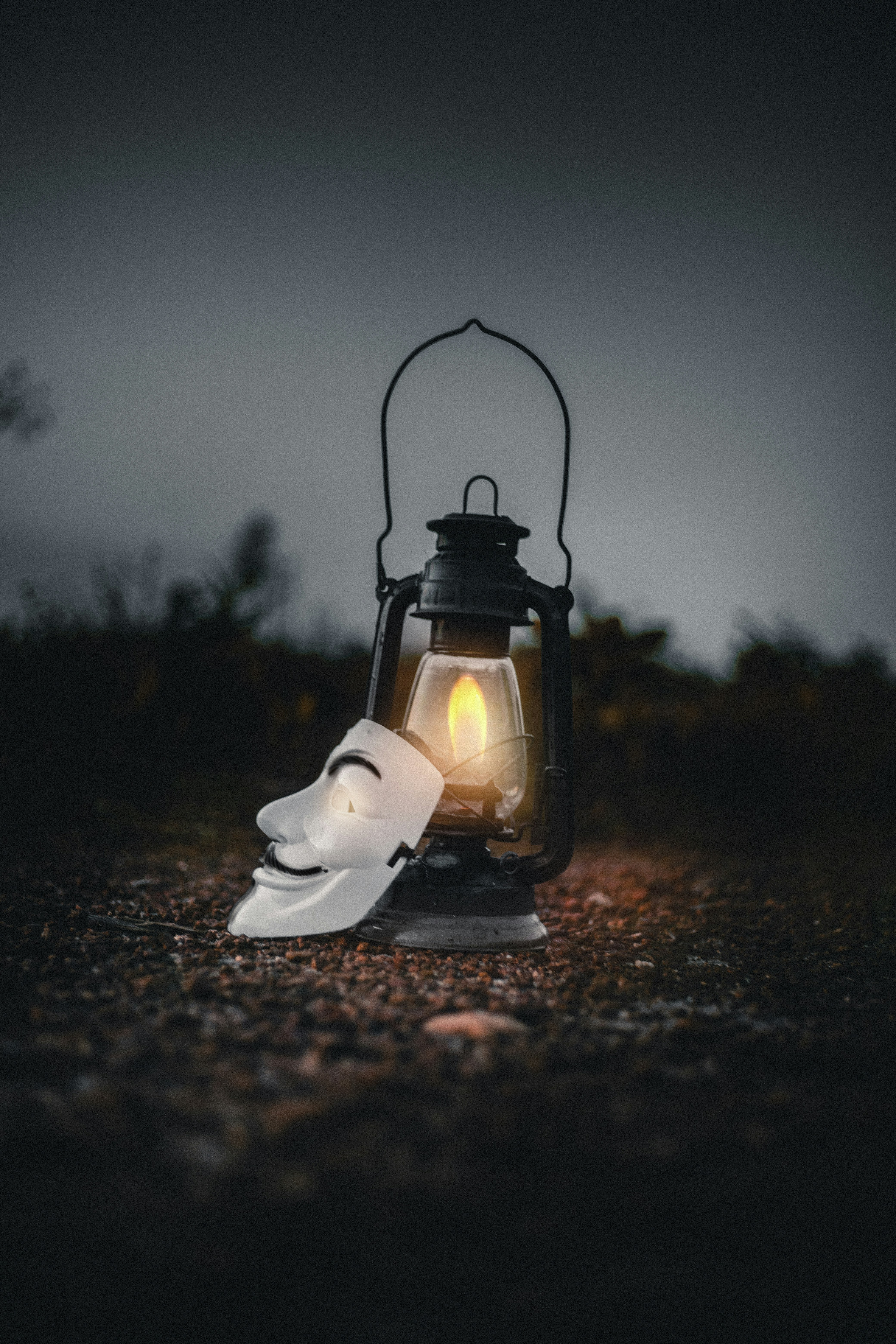 Ember Lantern and Mask on Gravel at Dusk: Quiet Night Ritual