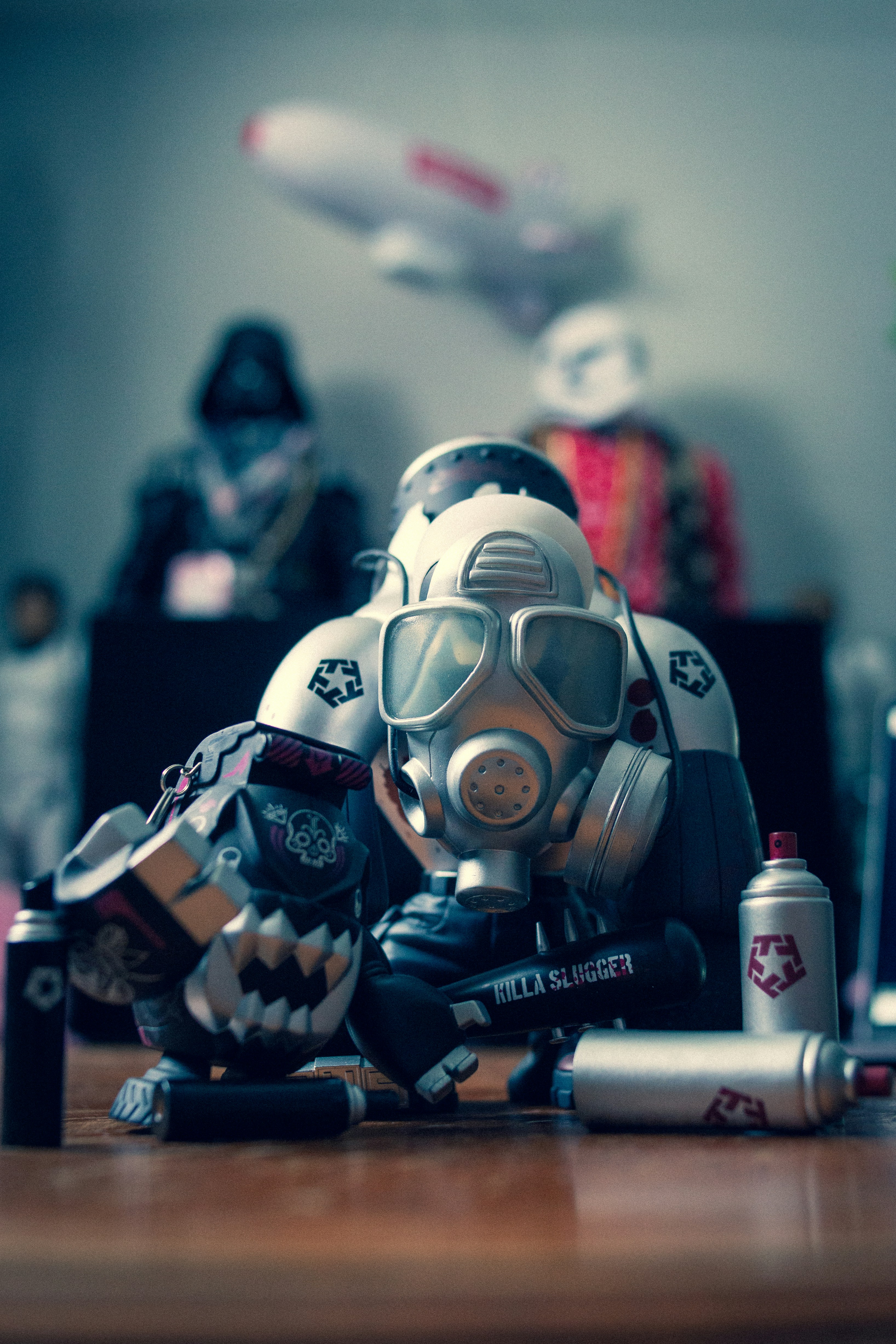 Gas Masked Toy Guardian Amid a Studio Mess of Spray Cans
