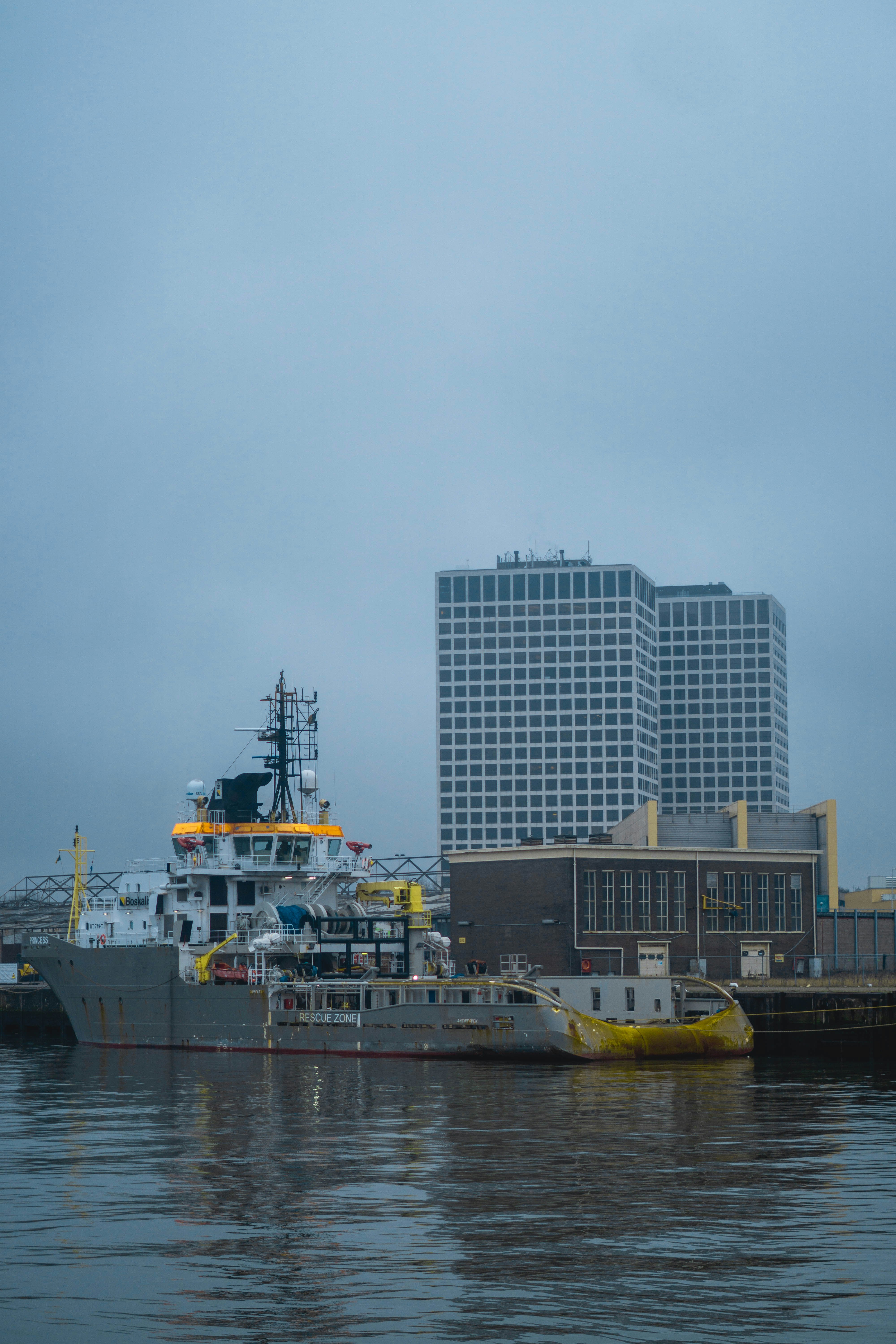 White and yellow ship on dock near city buildings during daytime photo ...