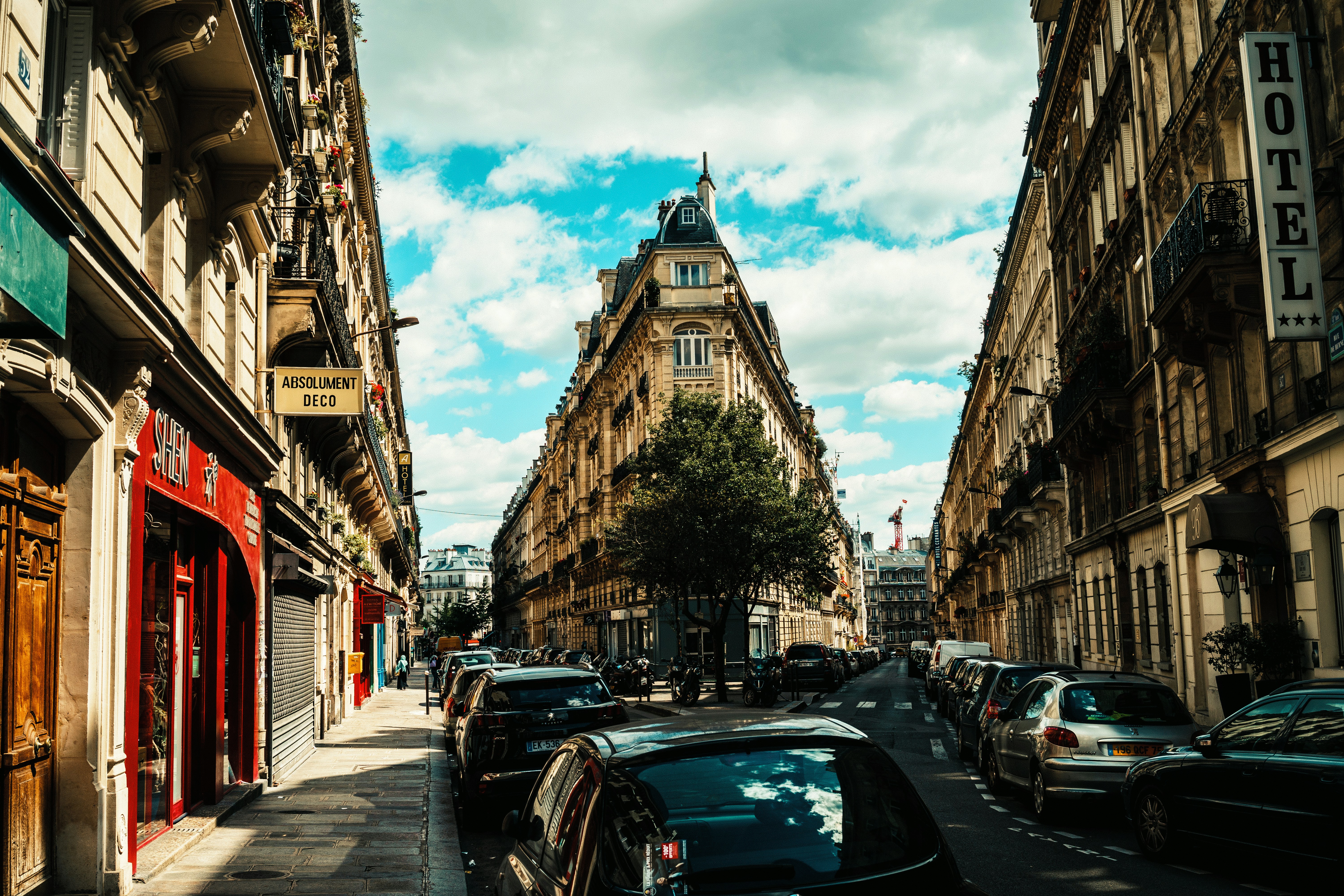 Cars parked on side of road near high rise buildings during daytime ...