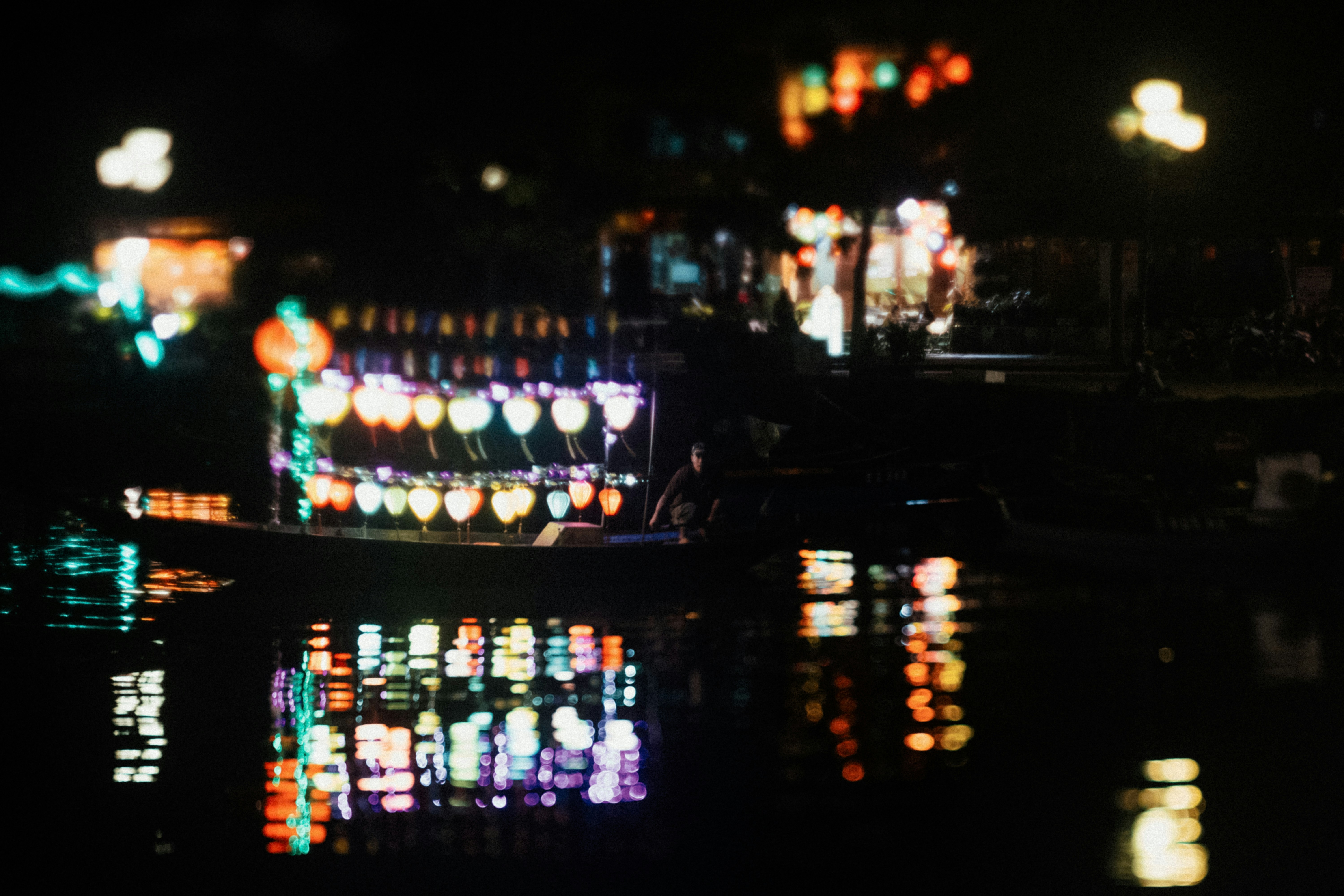 Floating Neon Reflections: Night Boat Parade on Dim Waters