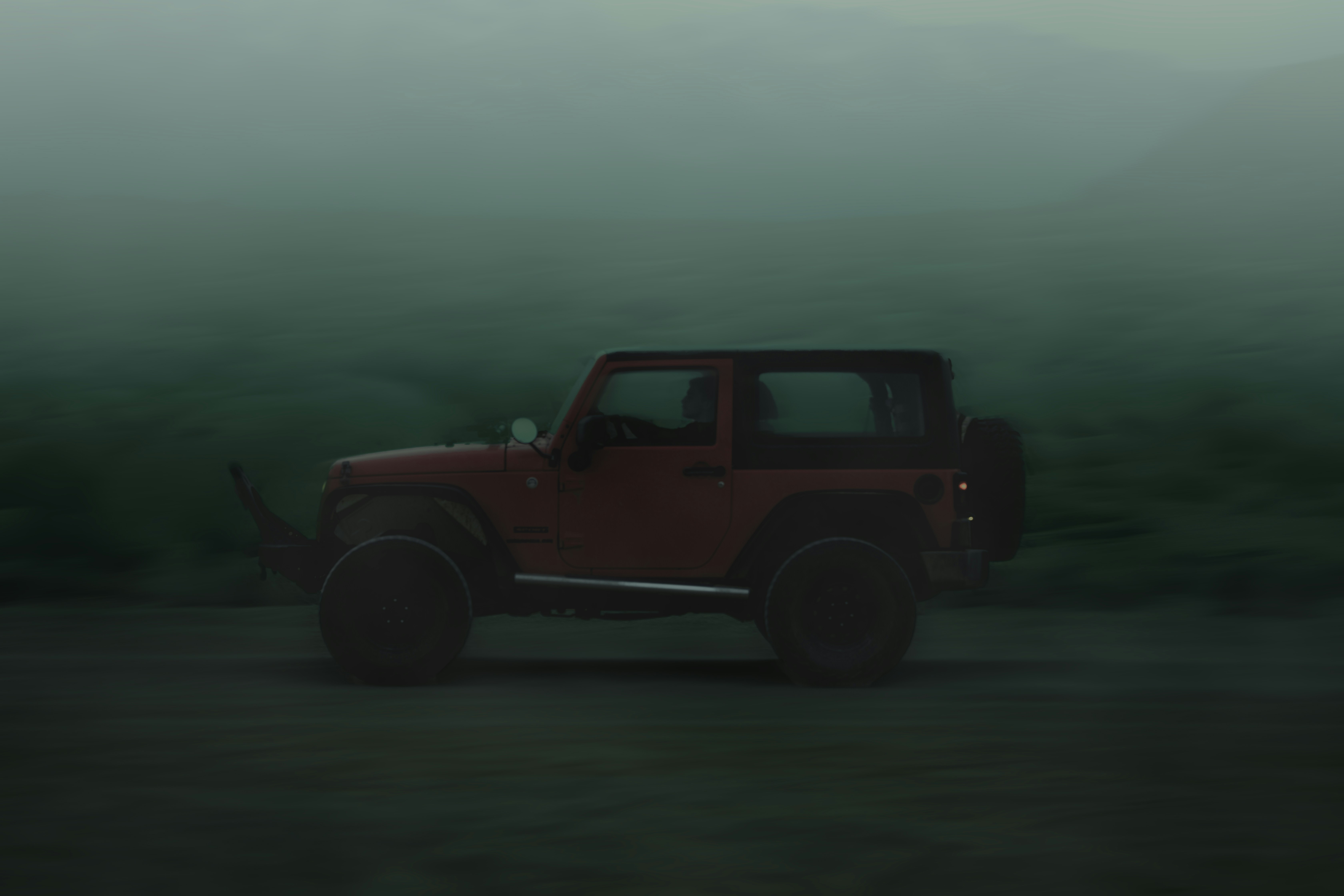Crimson Wrangler in Dim Twilight: A Gliding Off-Road Moment