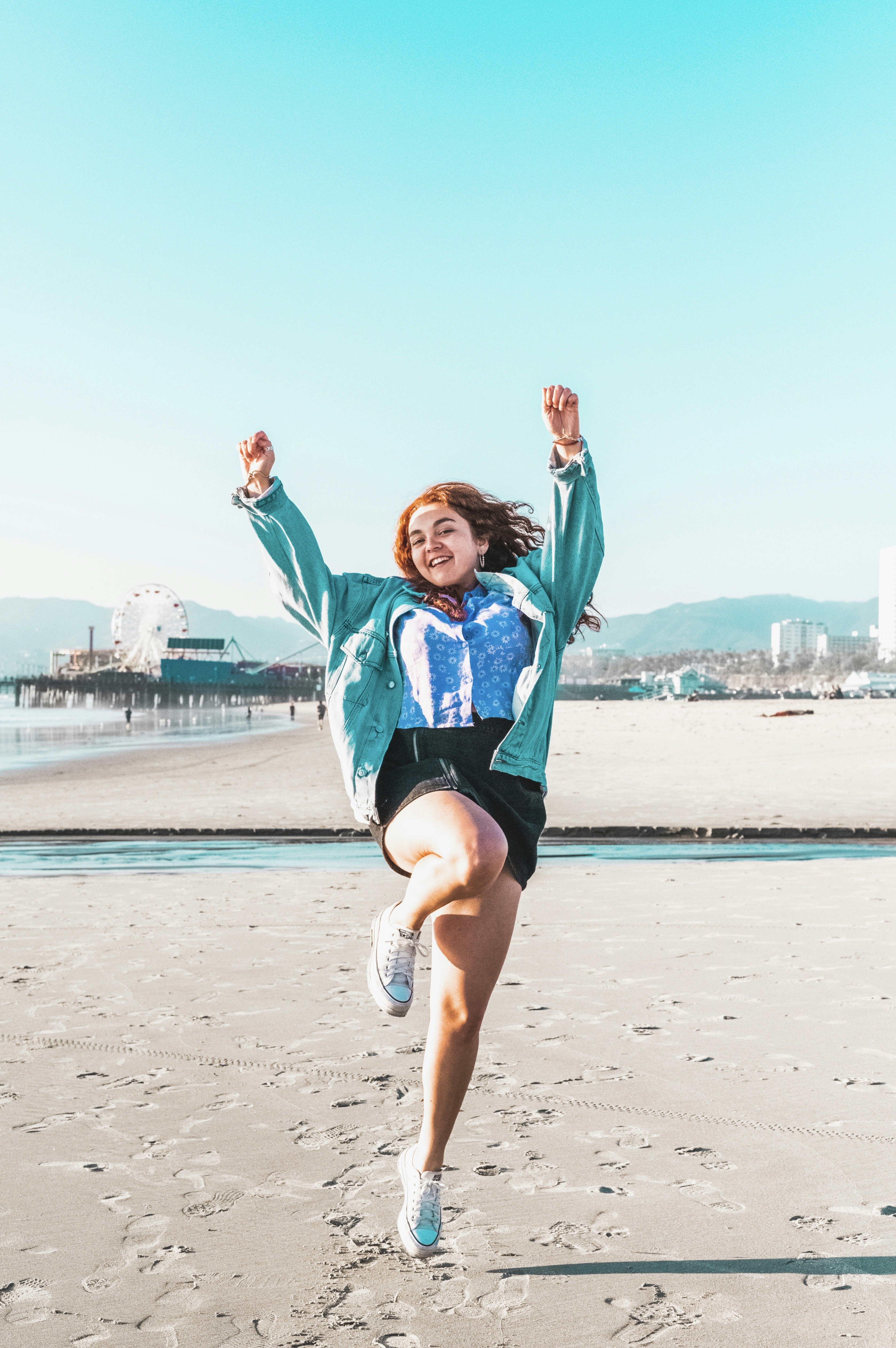 Sunlit Beach Jump by the Pier: A Burst of Joy