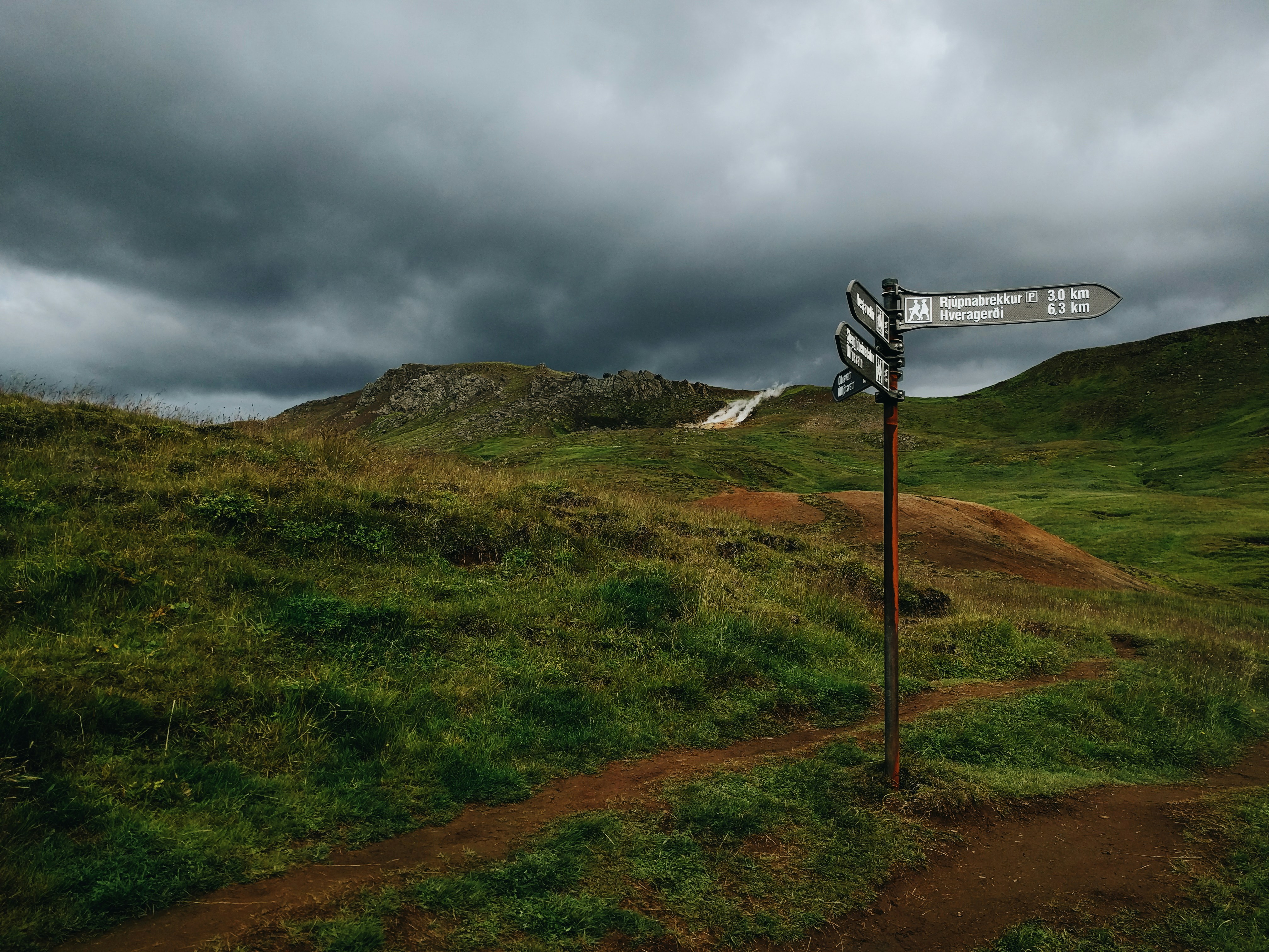 Signpost on a Windswept Moor Under Storm-Heavy Skies
