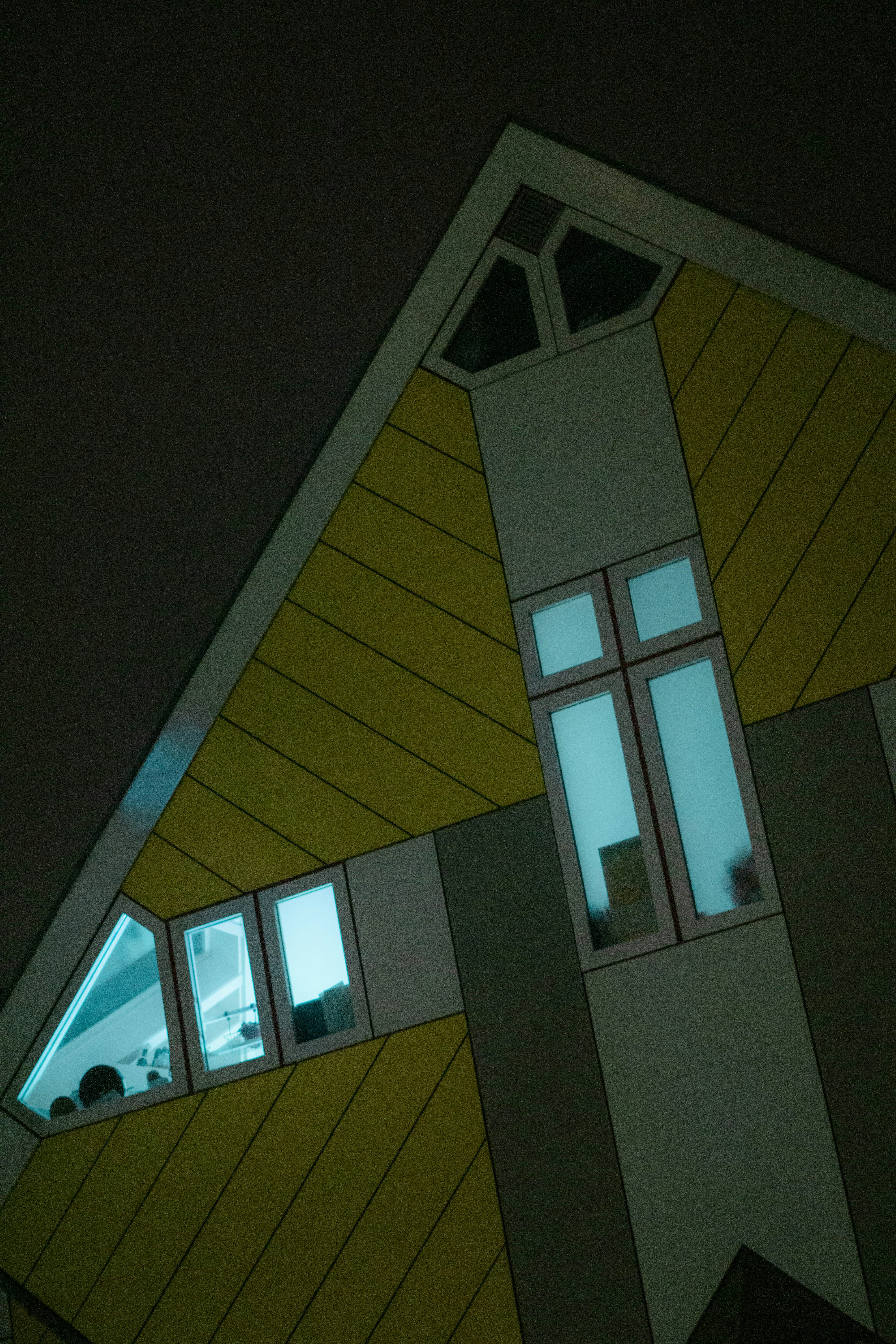Unique architectural design featuring illuminated windows against a dark backdrop, highlighting geometric shapes and colors.