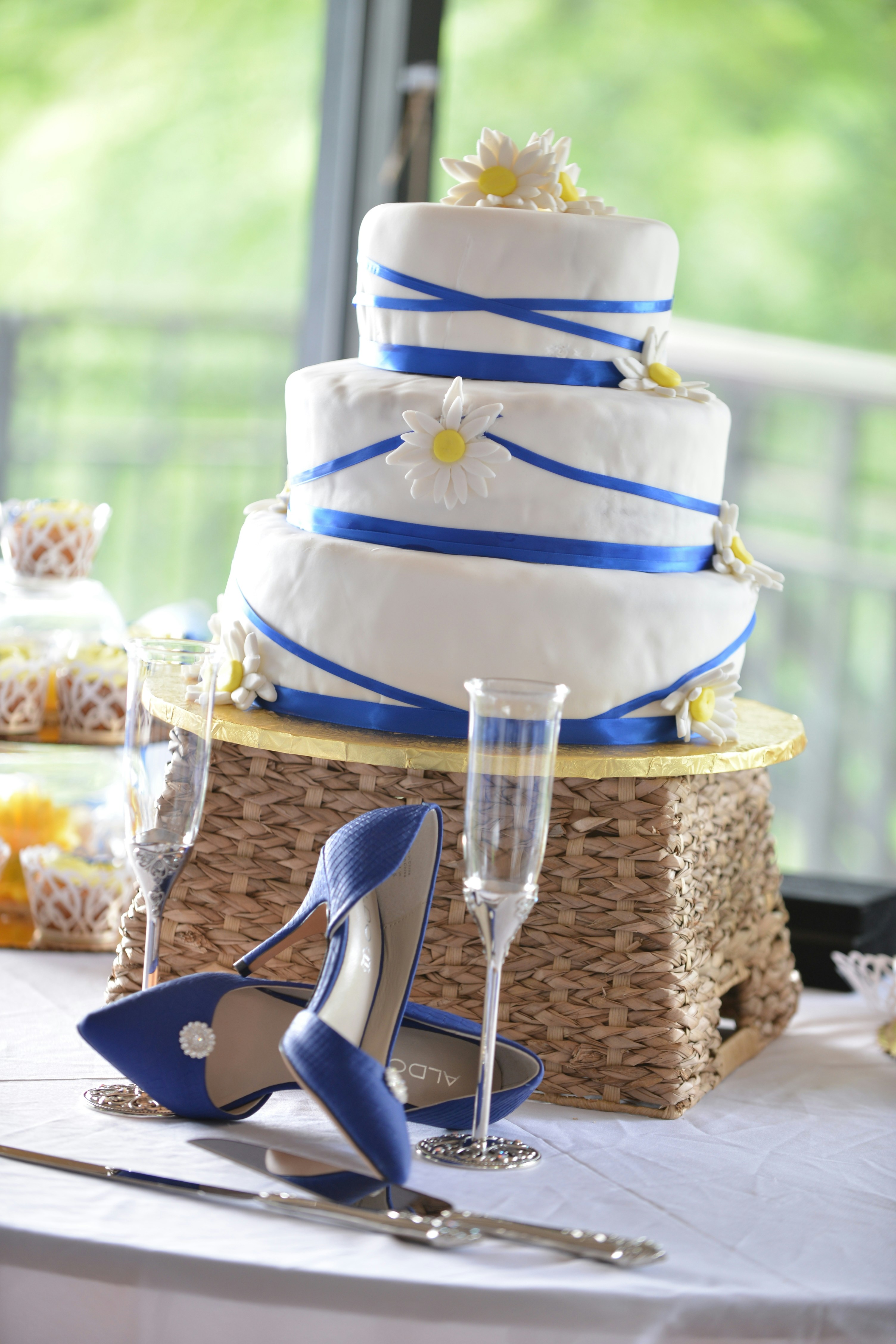 Blue Ribbon Bloom: A Three-Tier Wedding Cake on a Woven Pedestal