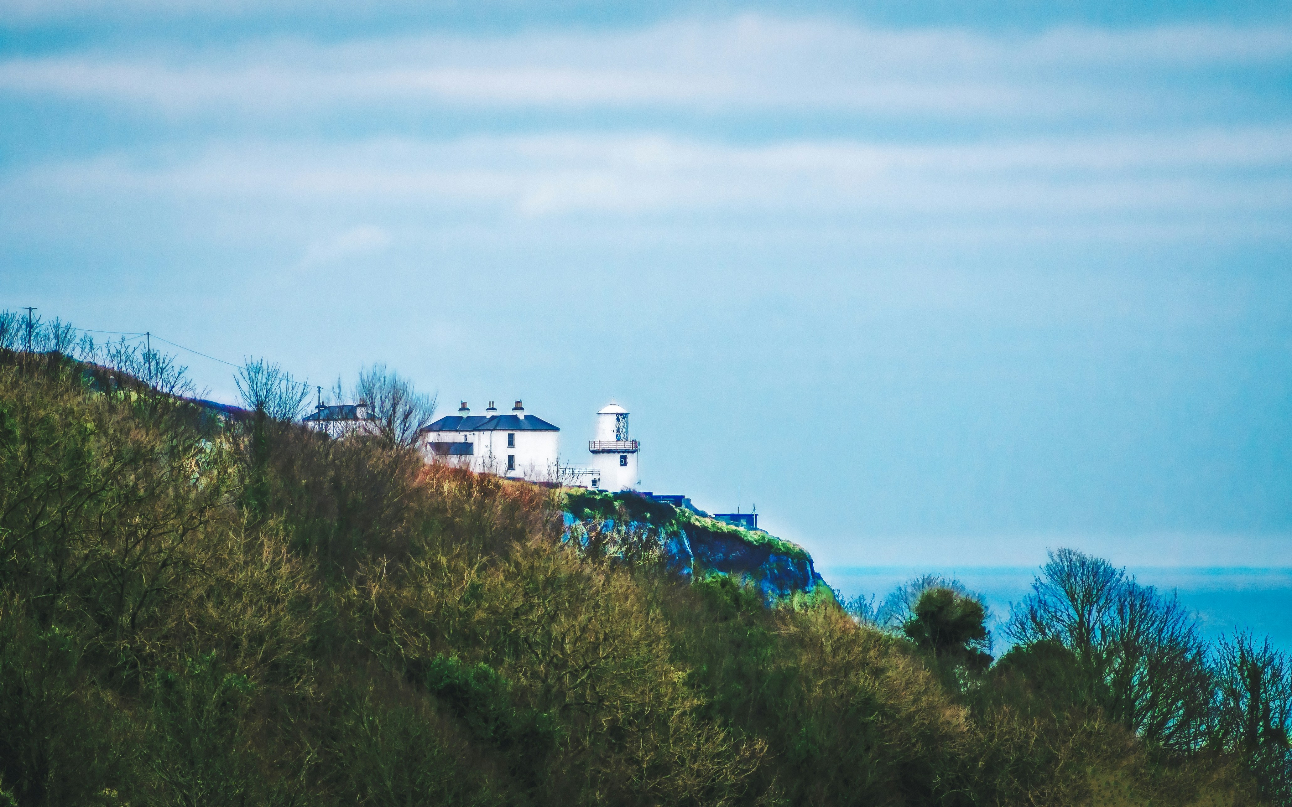 Cliffside Lighthouse: White Beacon among Spring Foliage
