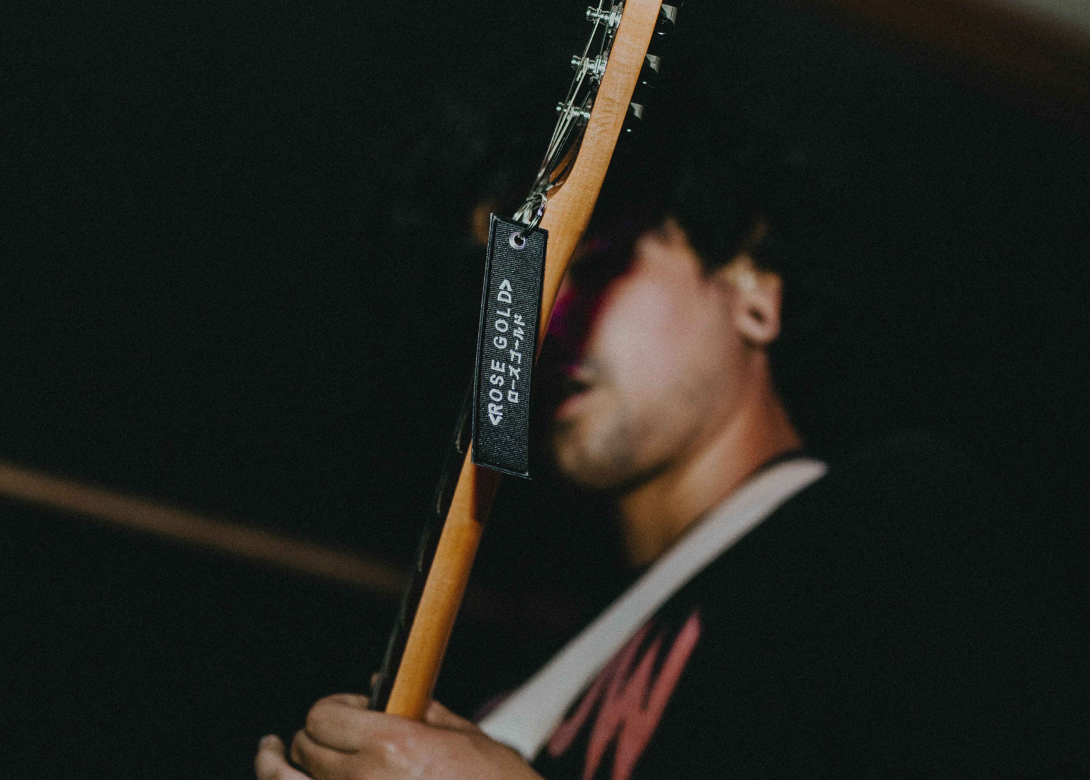 Neck-Tag Focus: A Guitarist in Dim Light