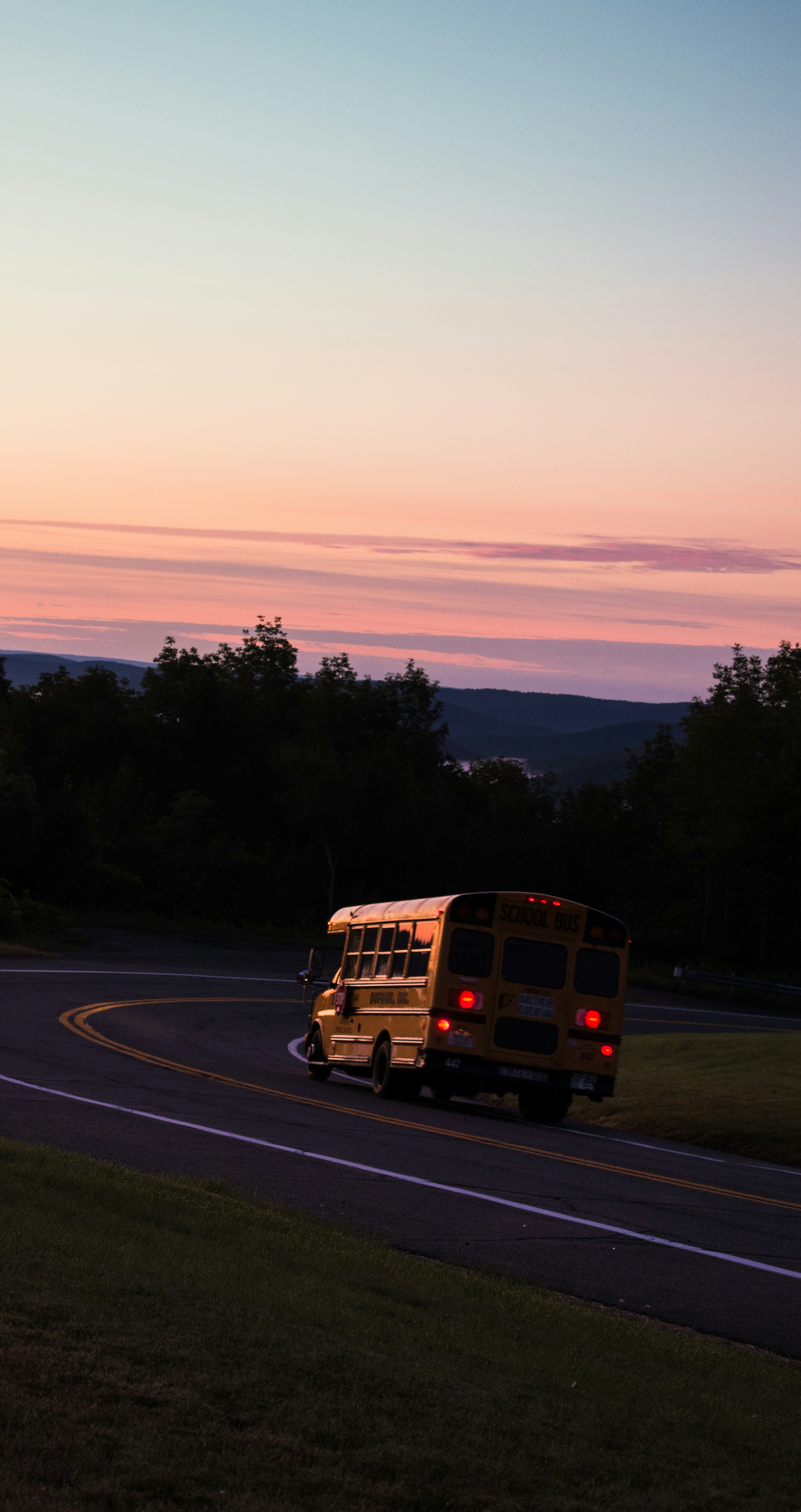 Dusk on the Bend: a Yellow School Bus Traces the Sunset Curve