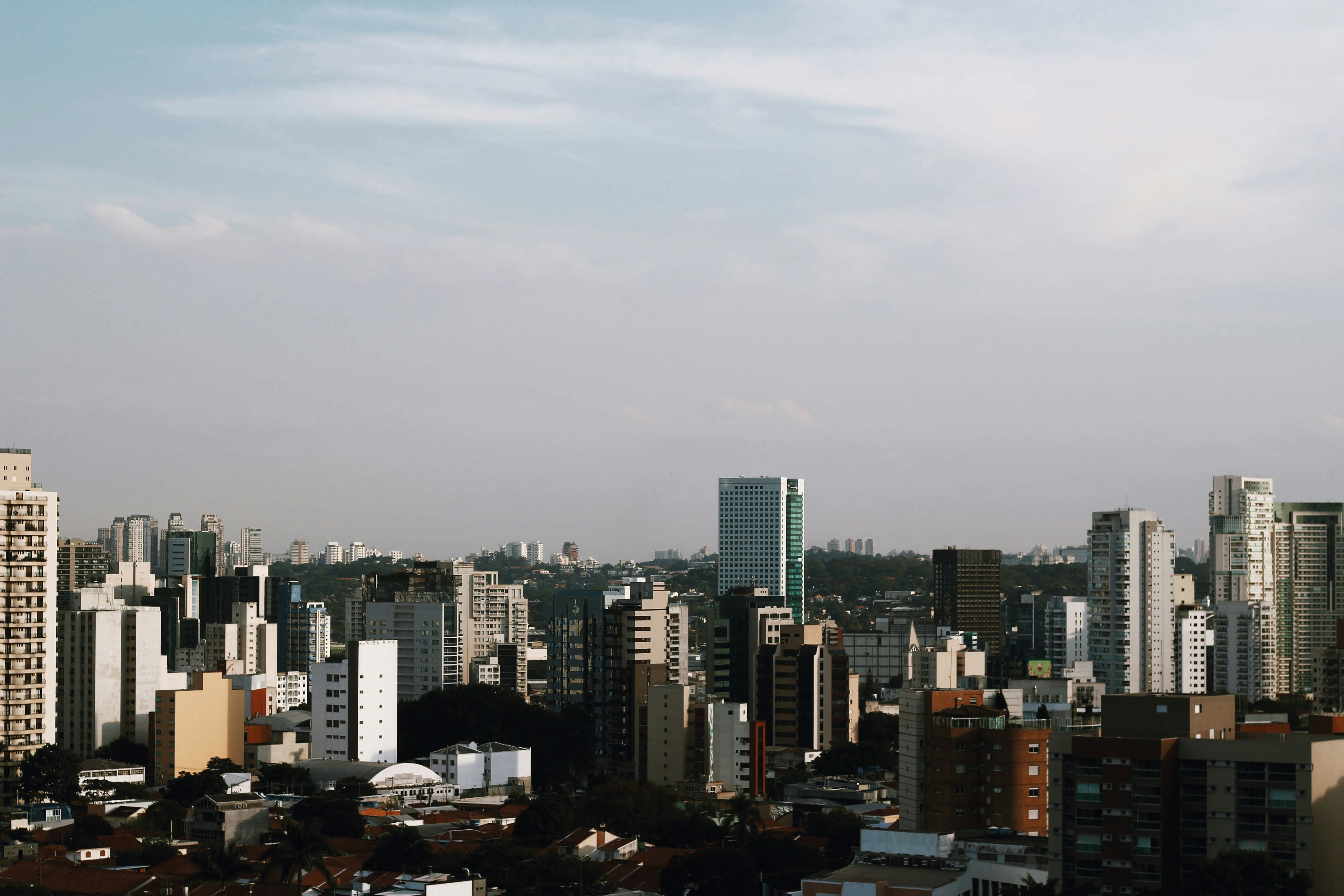 City skyline with diverse architectural structures under a cloudy sky.
