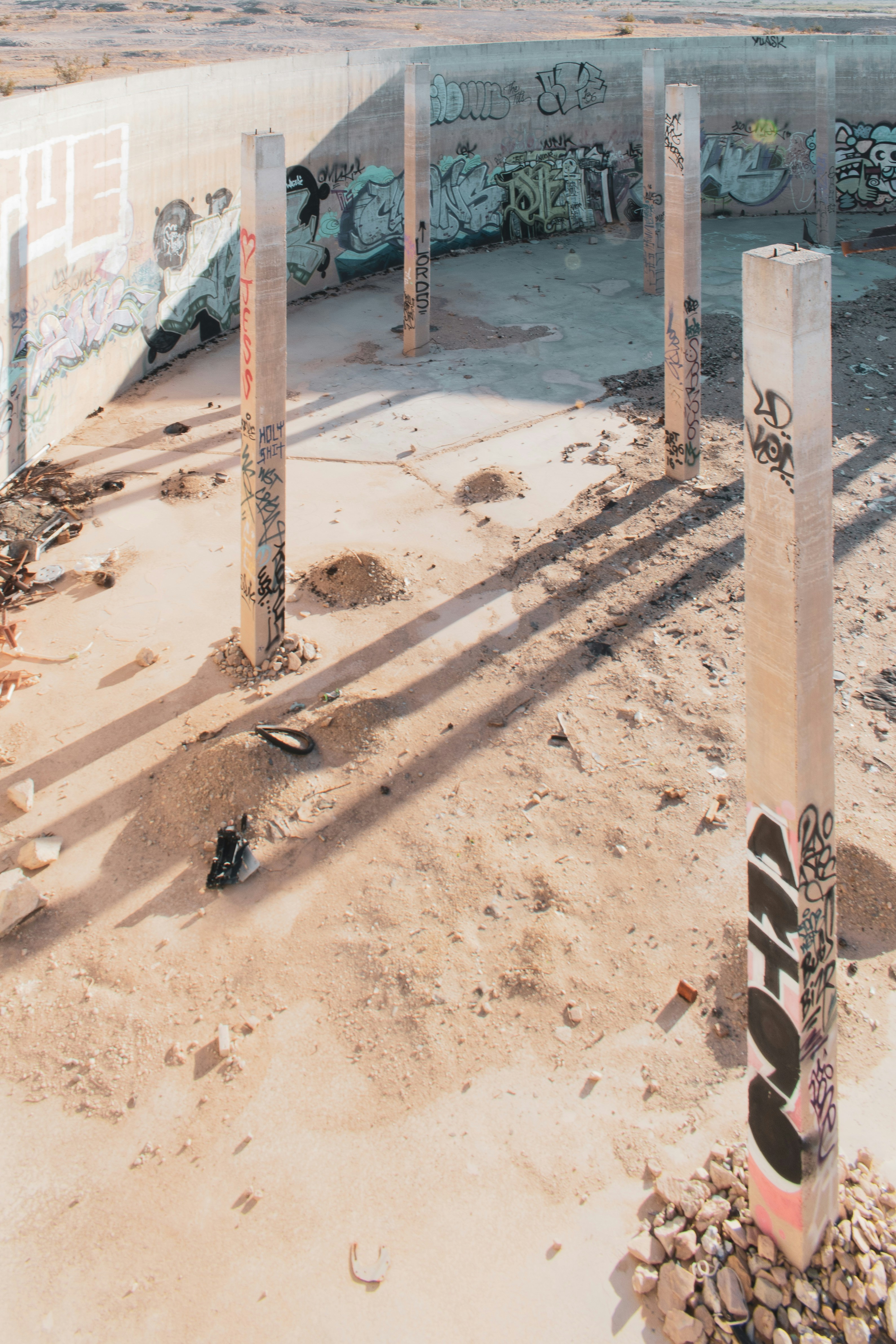 Deserted Concrete Columns Cast in Graffiti Shadows