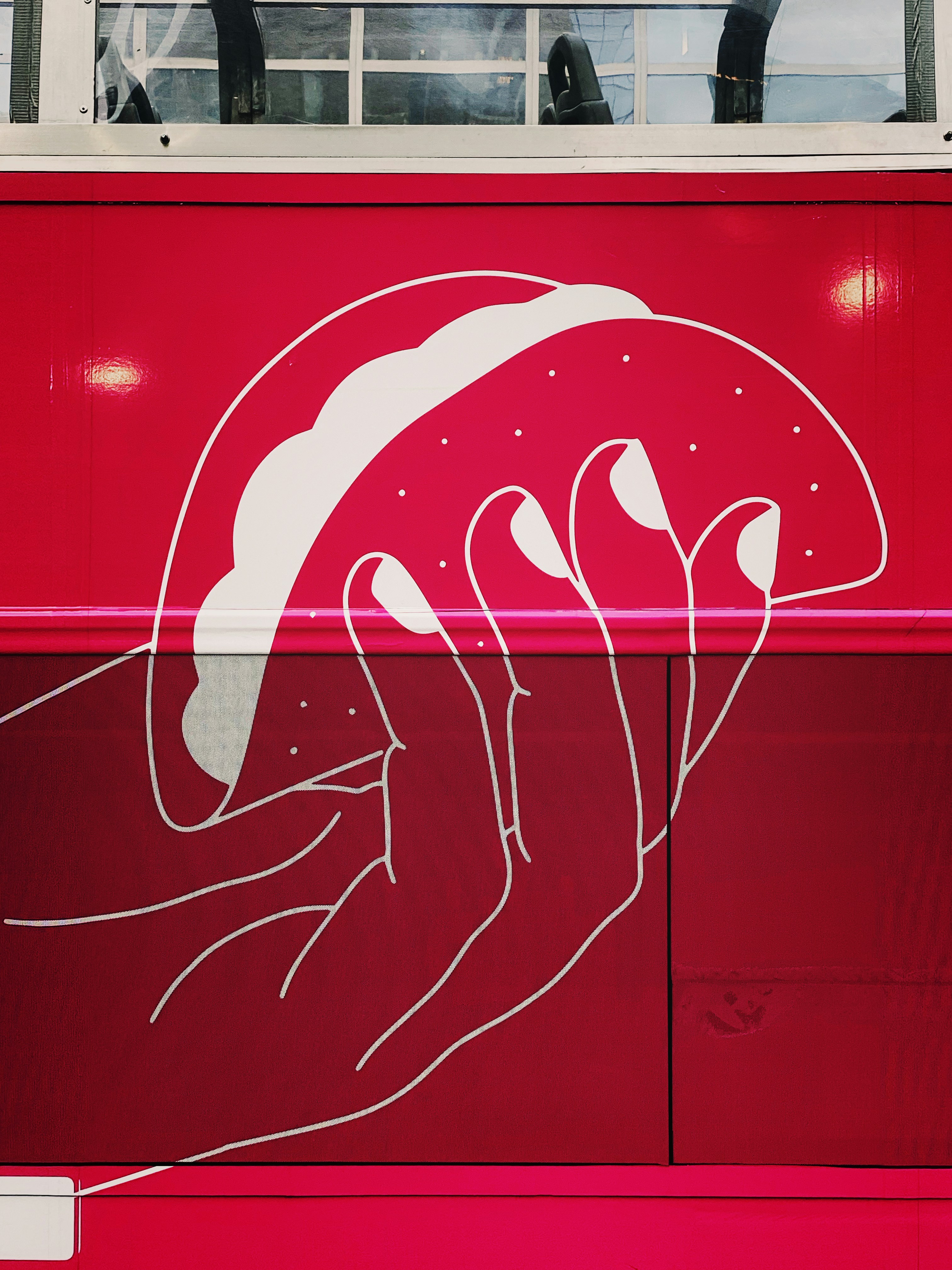 Crimson Lines: A White-Hand Mural on a Red Bus Panel