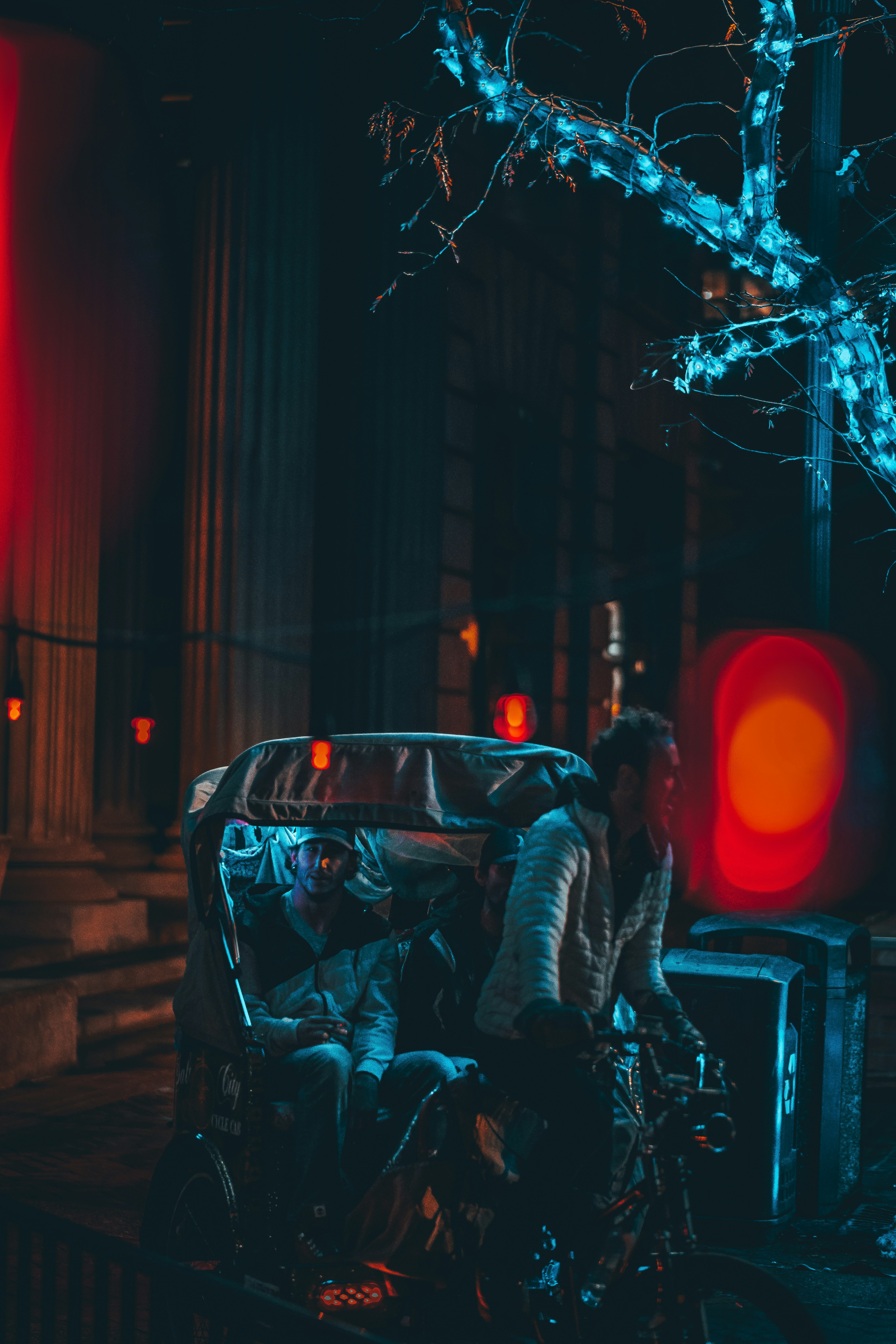 Blue-Glow Night Ride: Passengers in a Neon-Tinted City Rickshaw