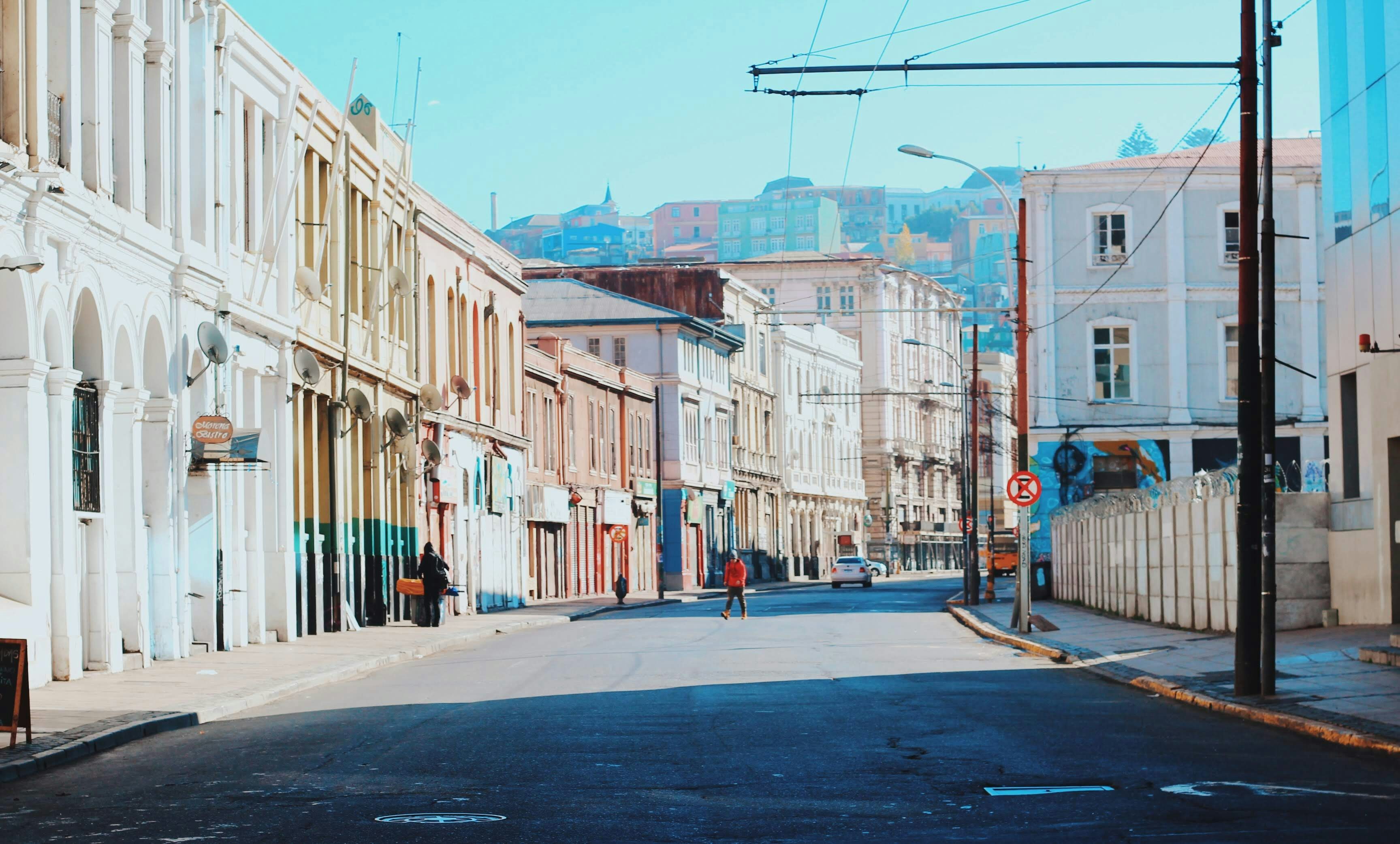 Quiet urban street lined with historic buildings and a clear blue sky.