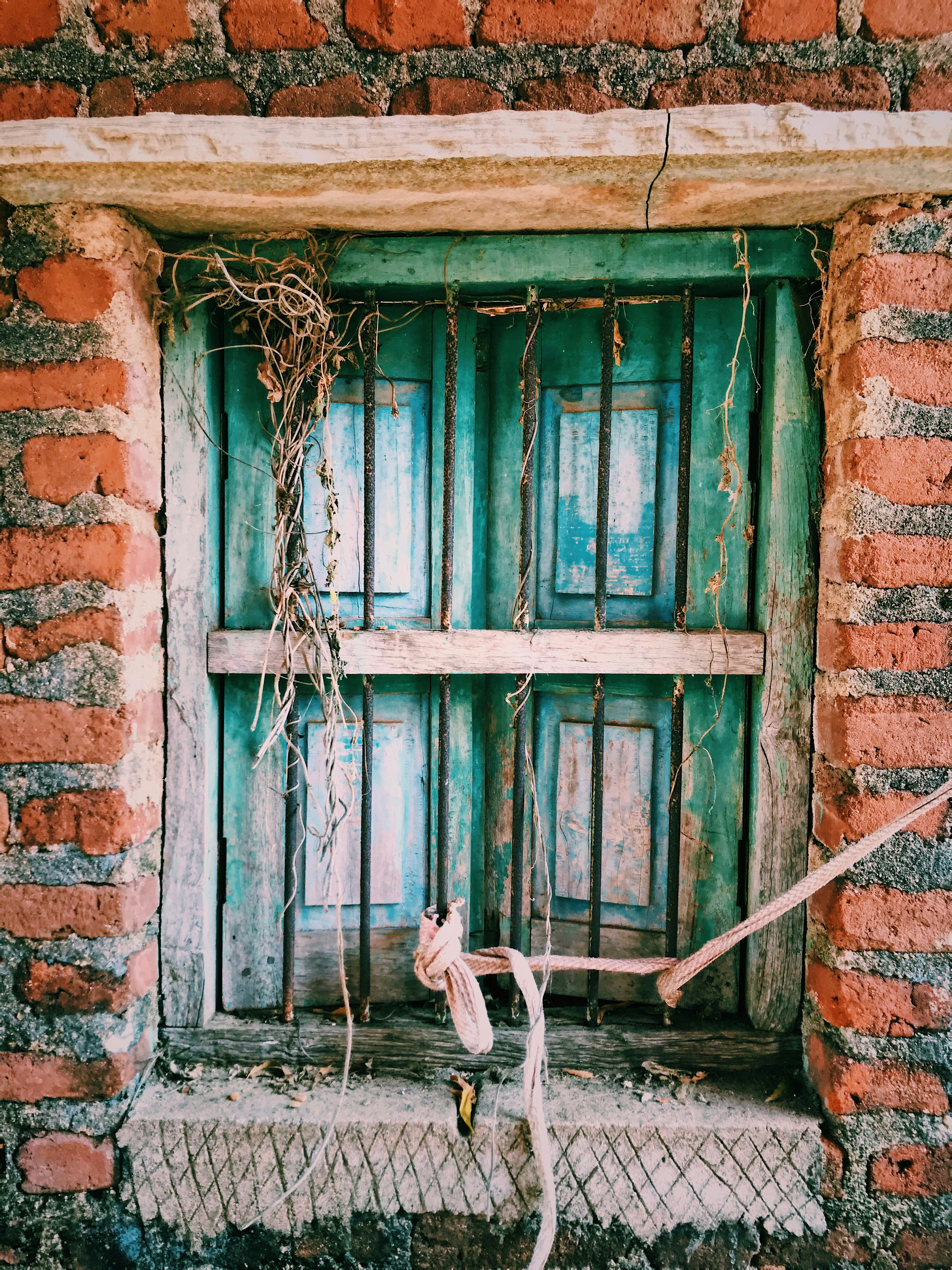 Weathered Green Doorway Framed by Crumbling Brick