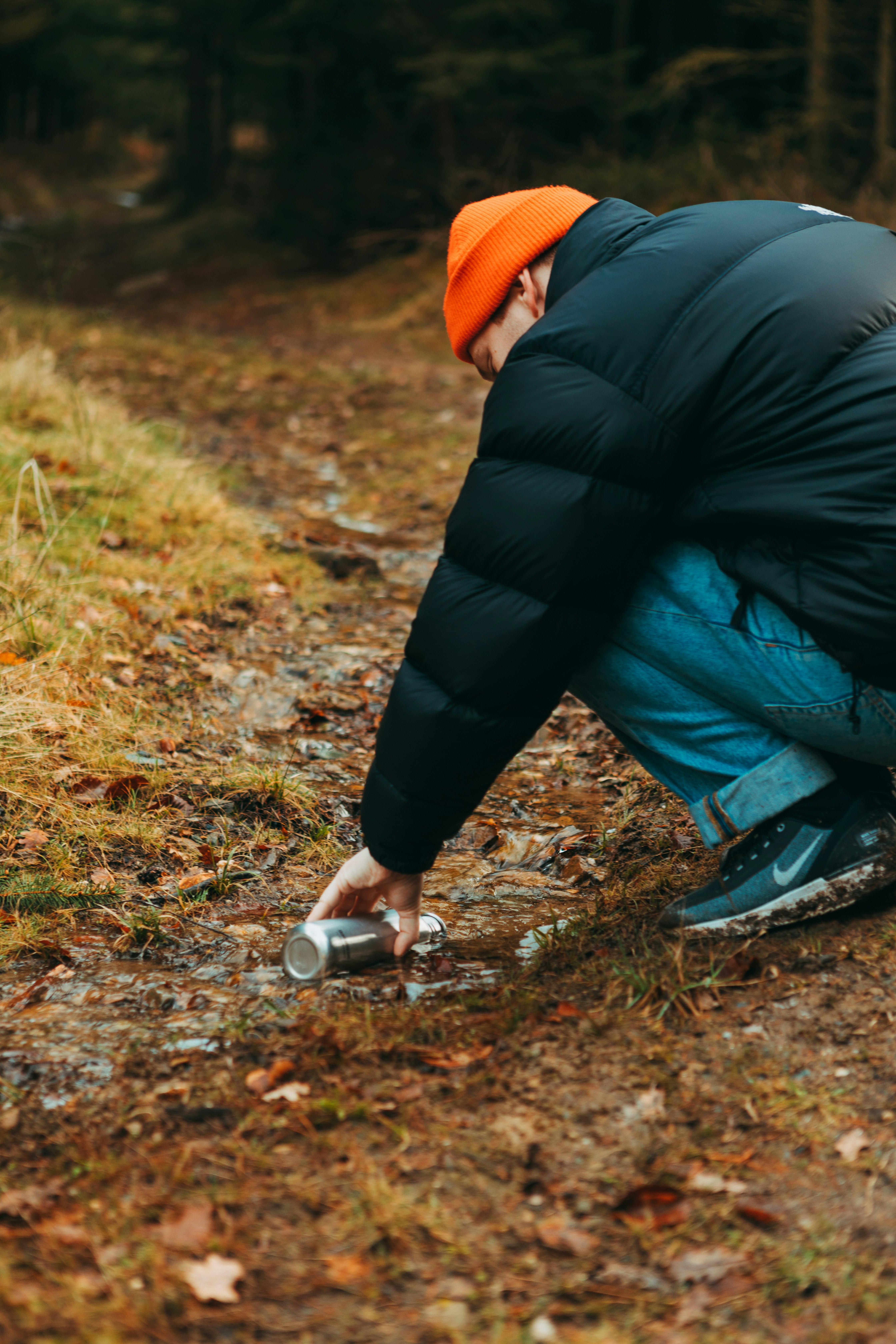Ground-Level Focus on a Forest Path: Reaching for a Can