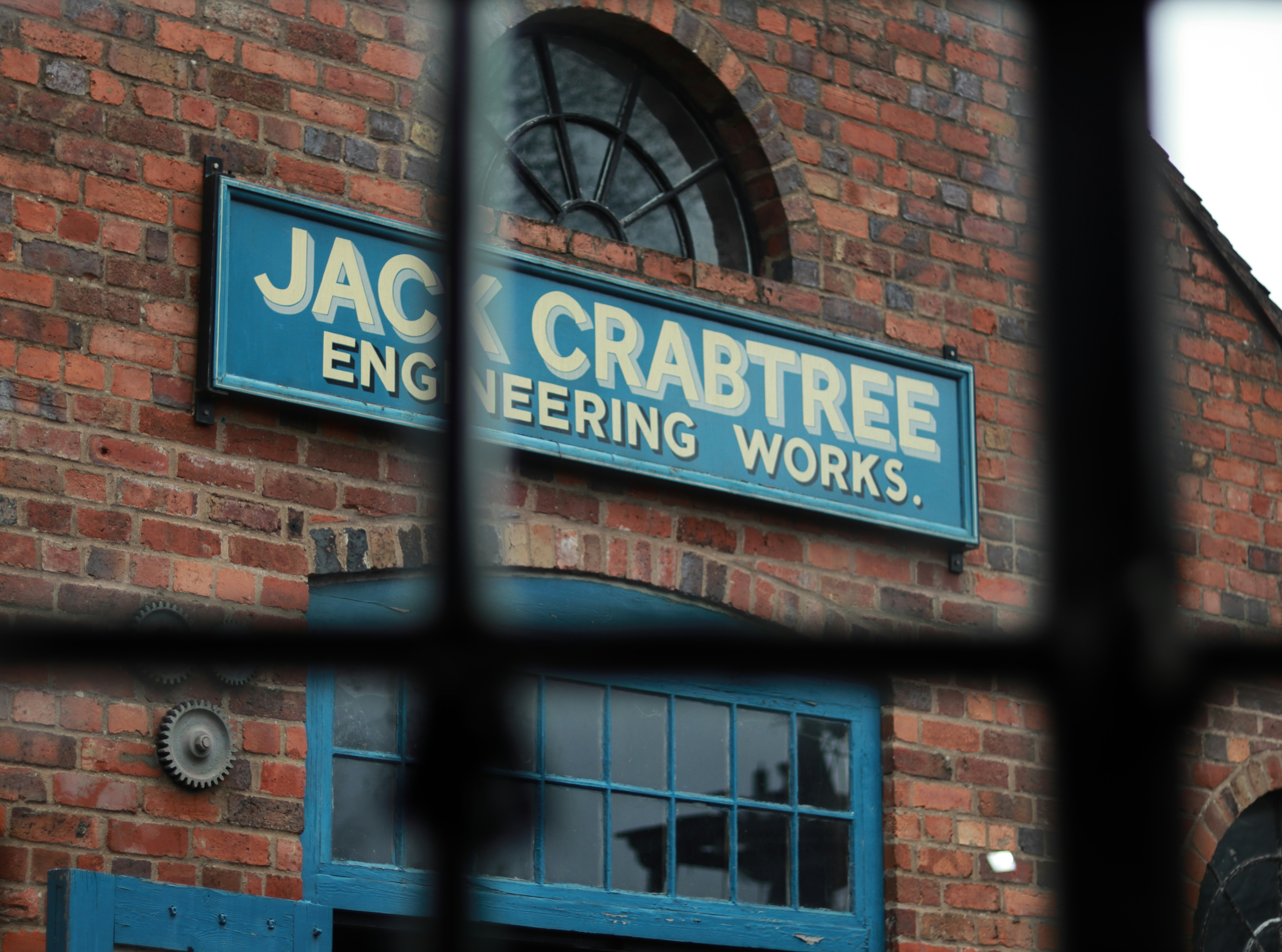 Sign Against Brick: Crabtree Engineering Works Through a Window