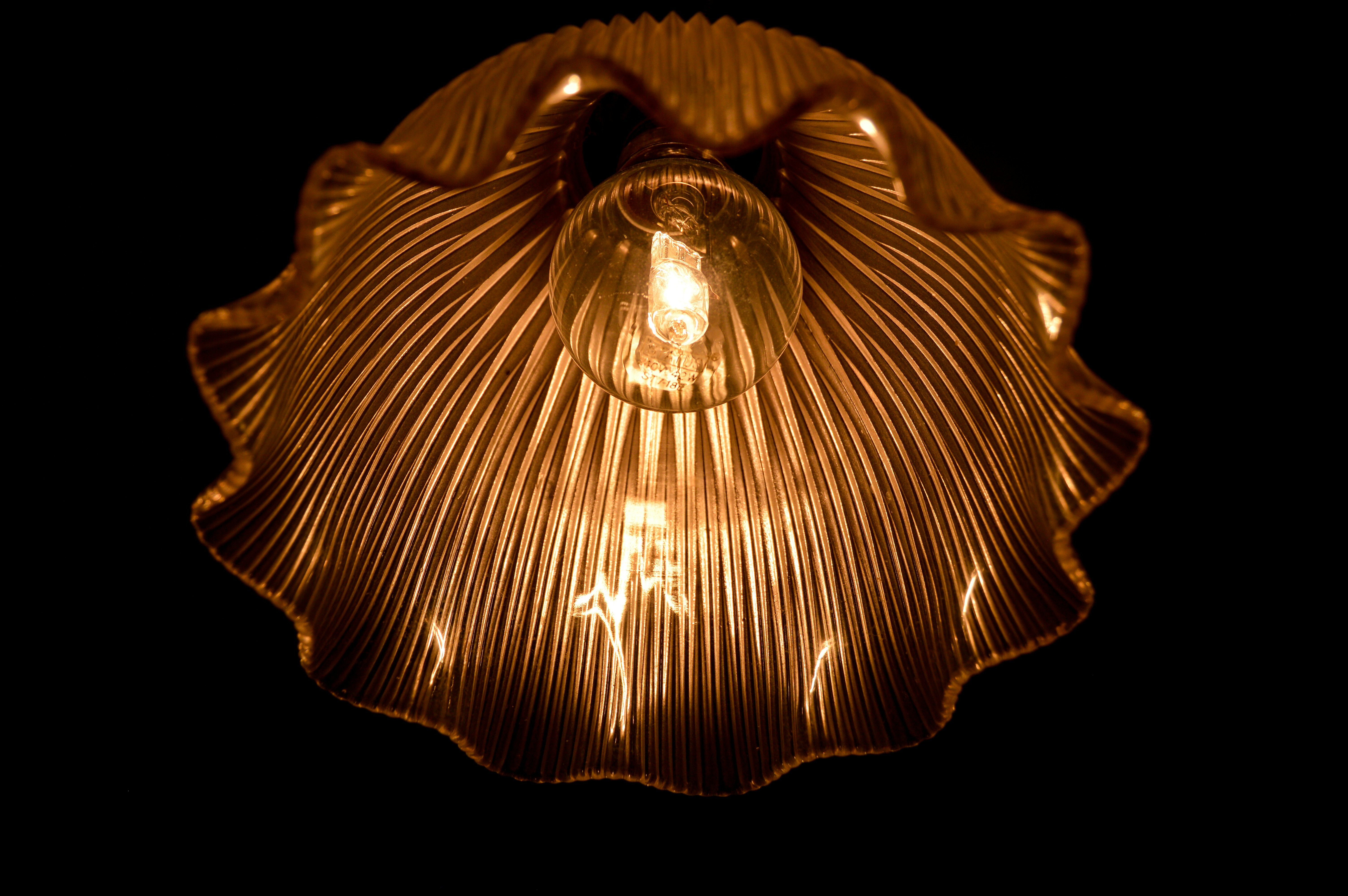Amber Halo: A Lone Filament Glows Inside a Ribbed Glass Shade