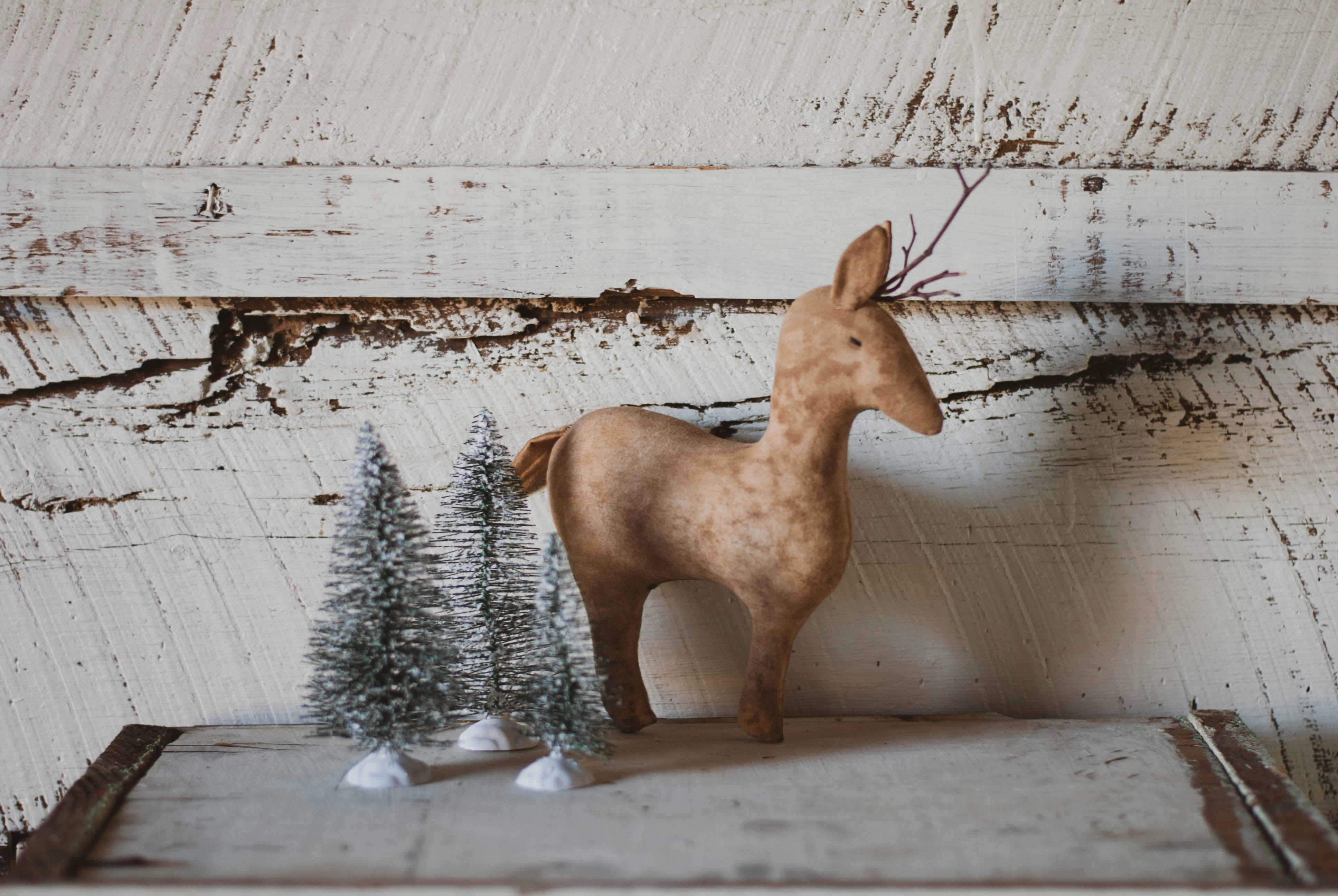 brown deer figurine on white wooden wall