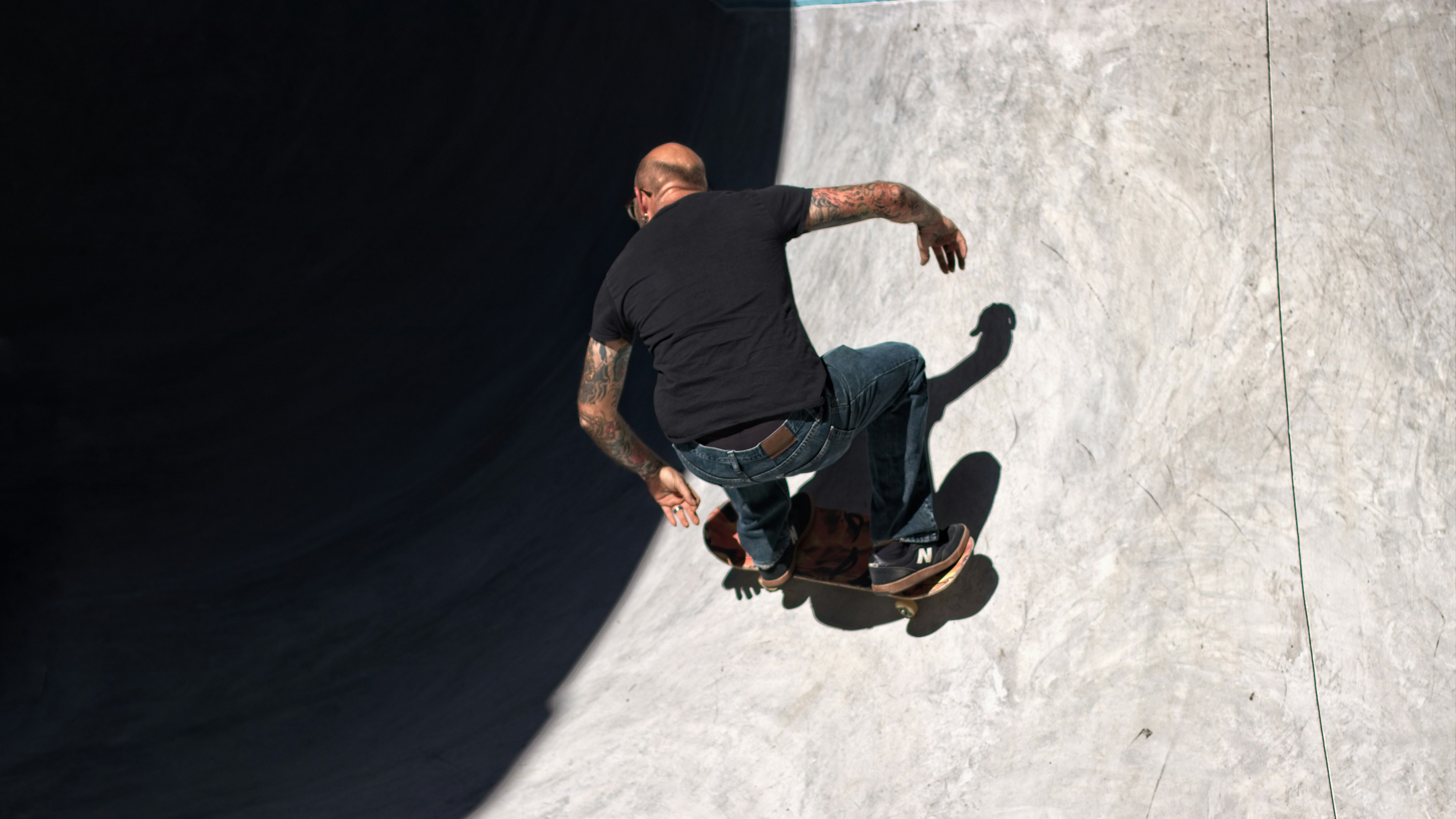 Midair Glide: The Skater Carves Shadowed Concrete