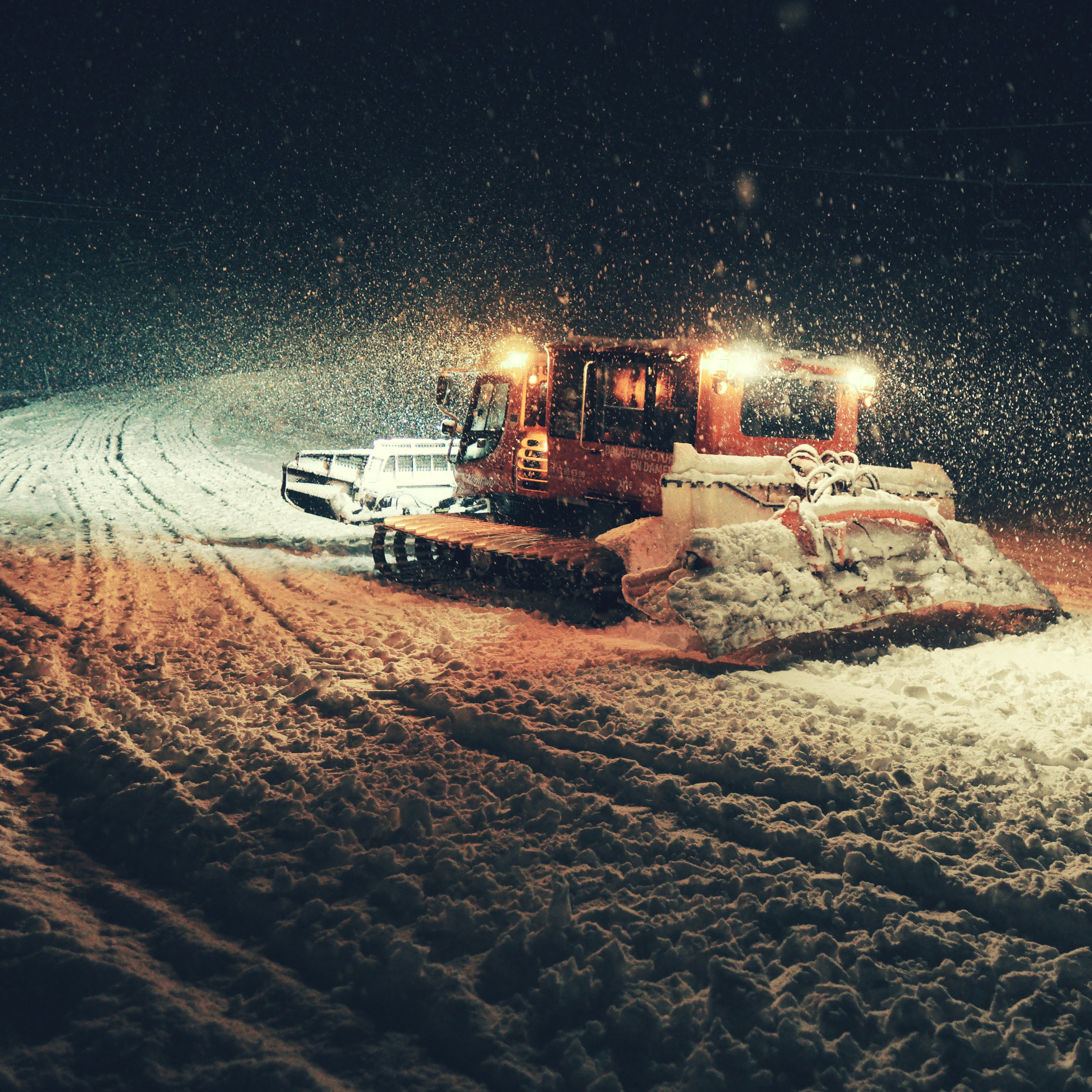 Snowbound Beast: A Red Snowplow Cleans a Night-Road Under Starry Snowfall