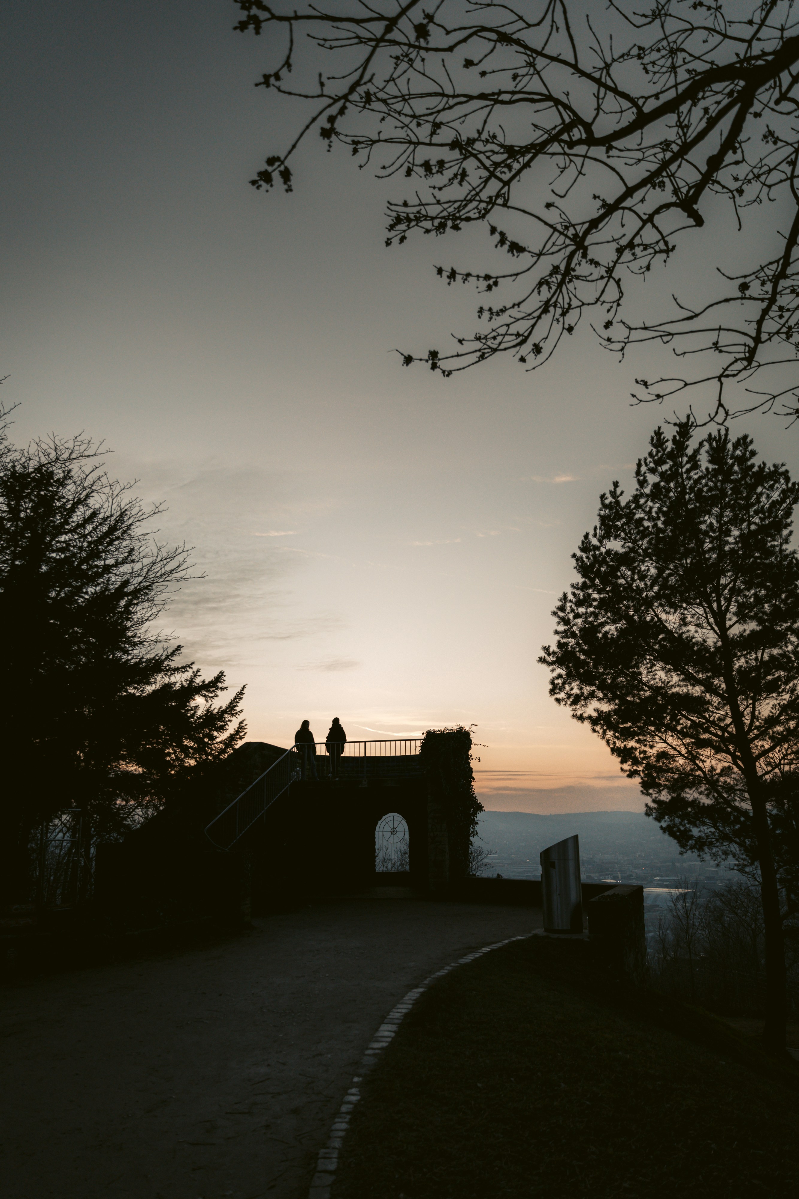 Dusk at the Arch Overlook: Two Silhouettes on a Stone Terrace