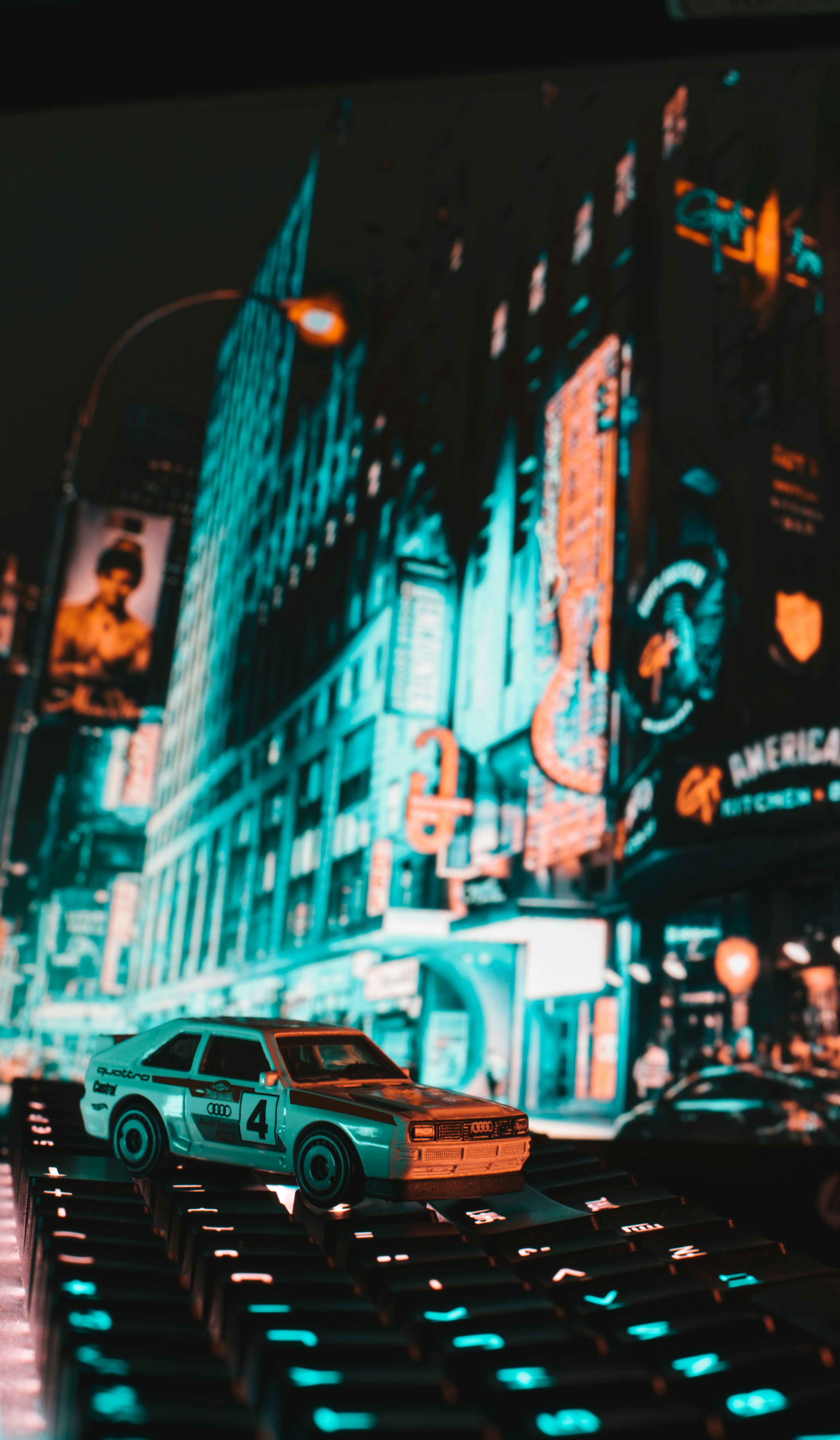 A toy car positioned on a keyboard, set against a vibrant neon cityscape backdrop. The scene combines elements of play and urban life.