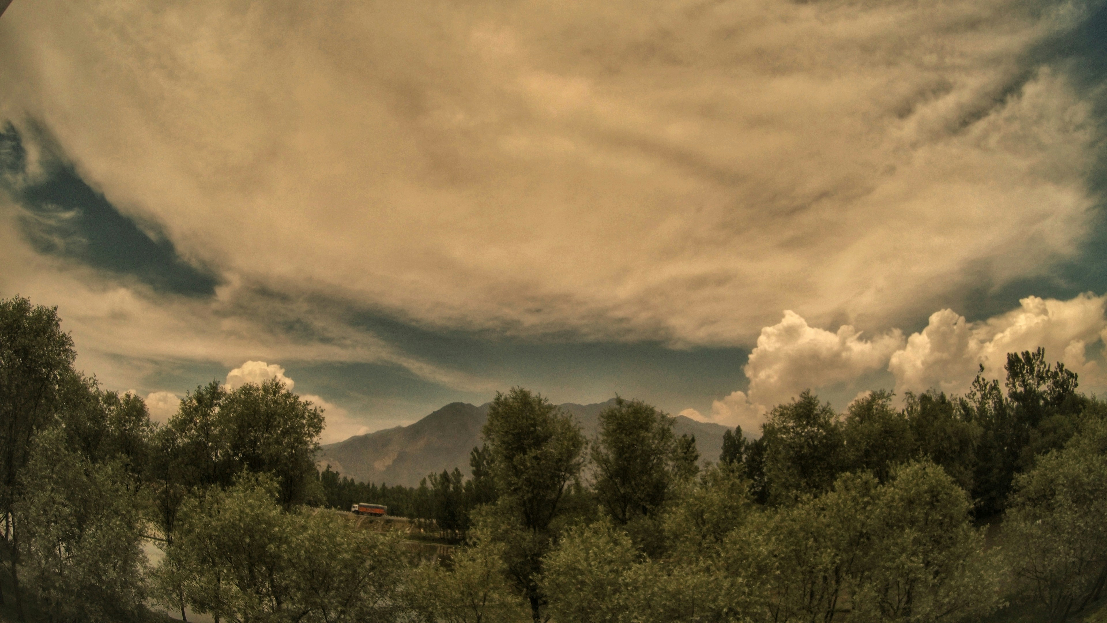 Ember Sky Over a Quiet Forested Valley with Distant Peaks
