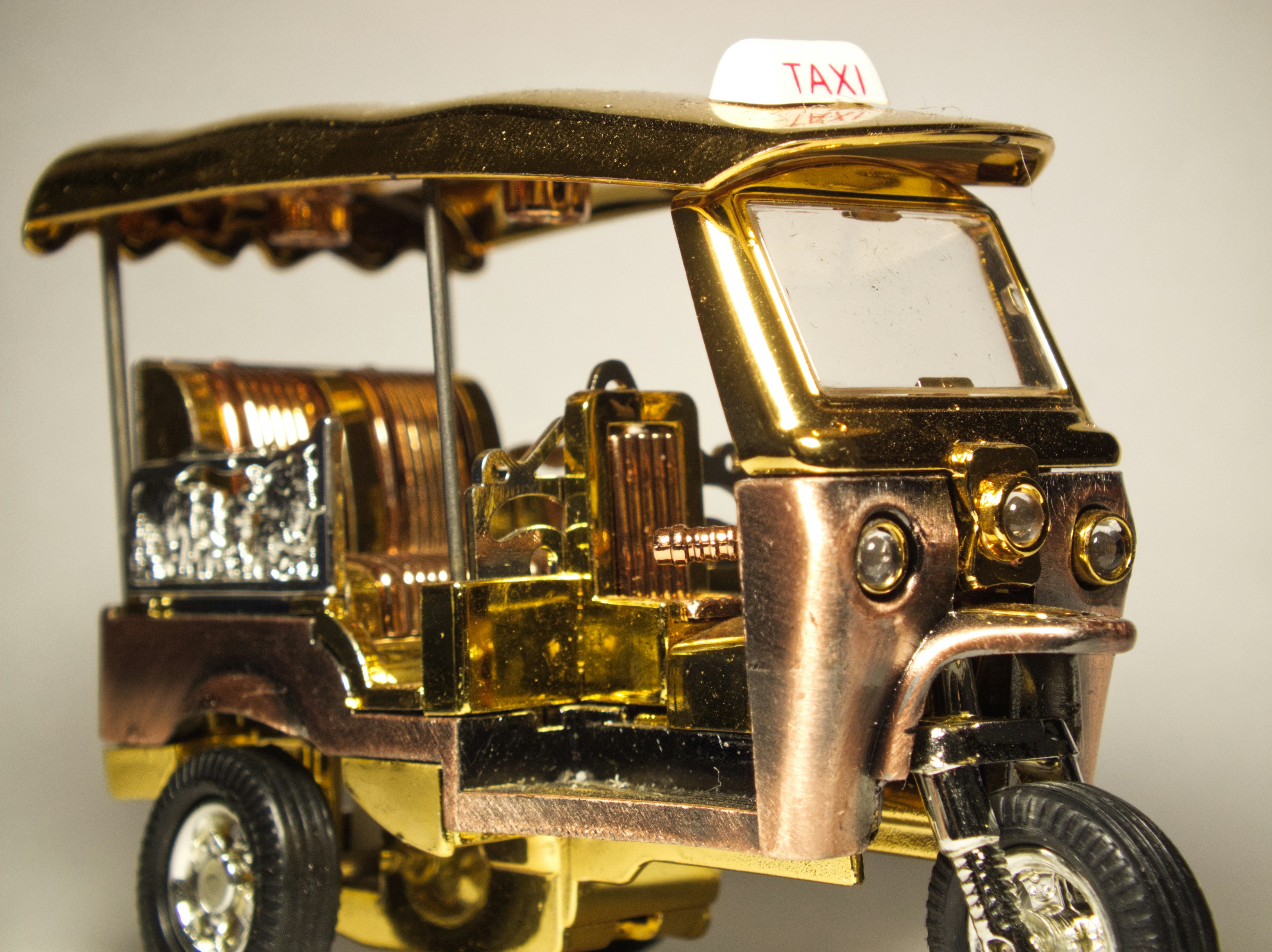Detailed miniature taxi model showcasing intricate craftsmanship and a shiny gold finish.