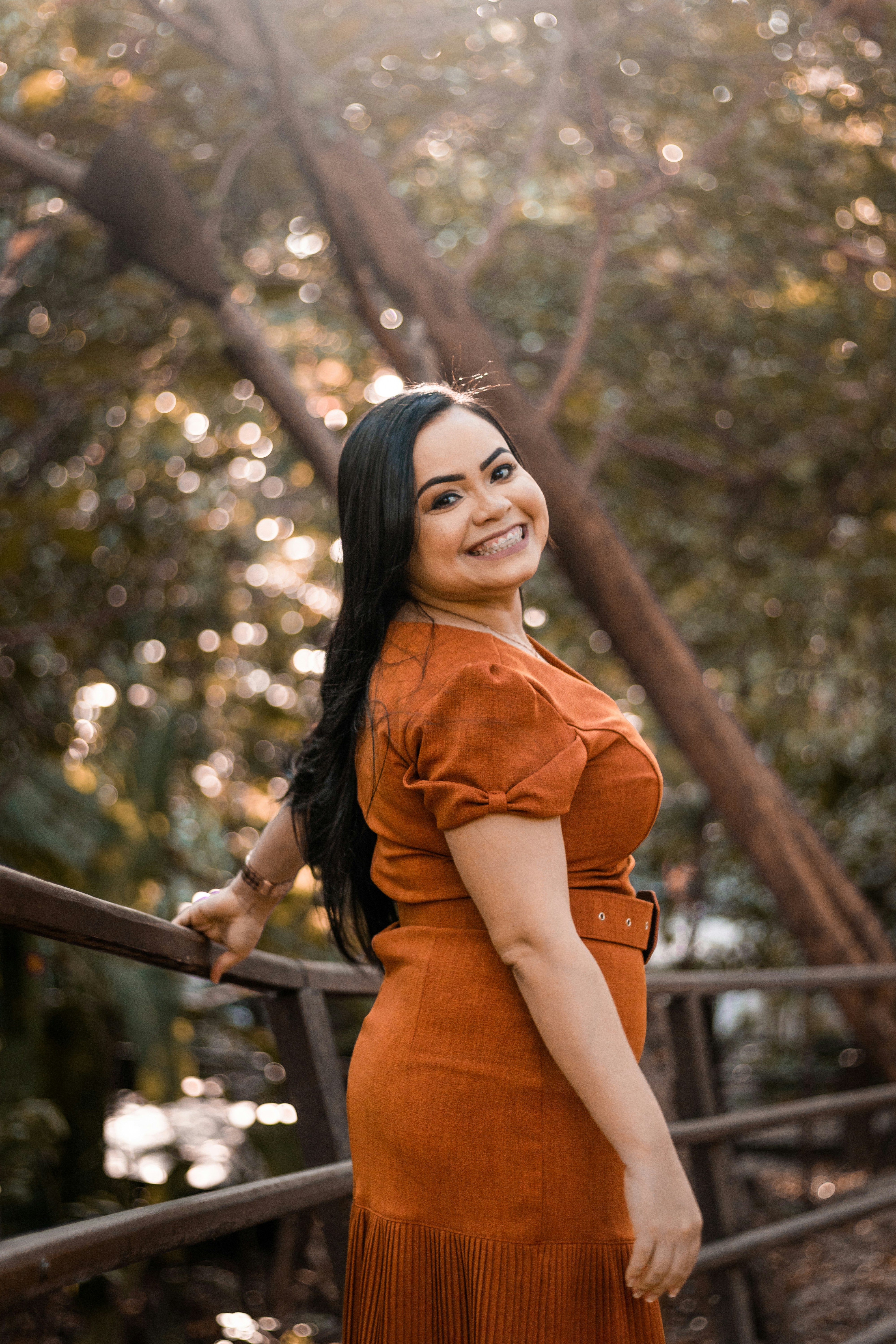 Sunlit Smile on the Bridge: Warm Ember Dress Portrait