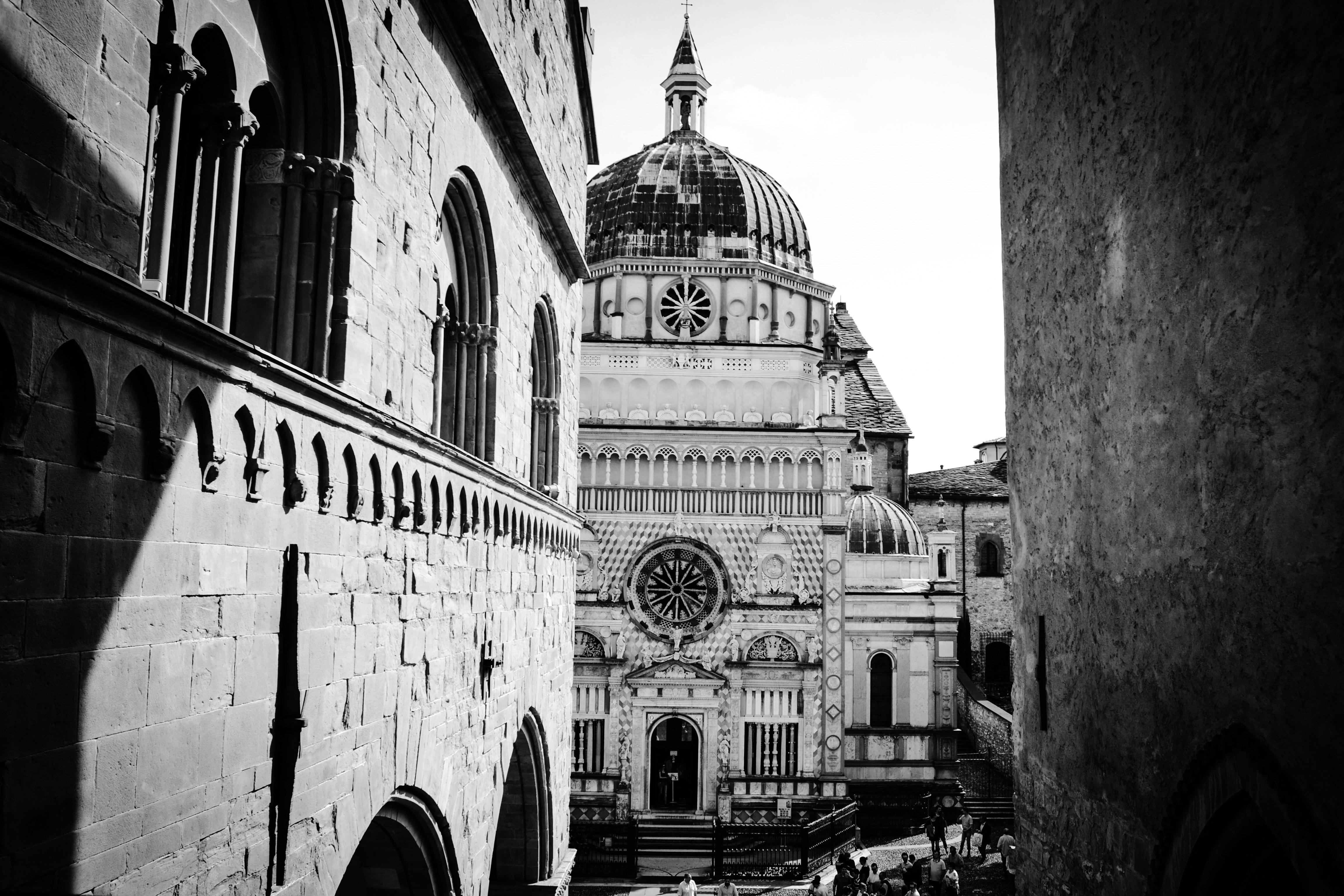 Monochrome view of an ornate cathedral dome framed by historic buildings.