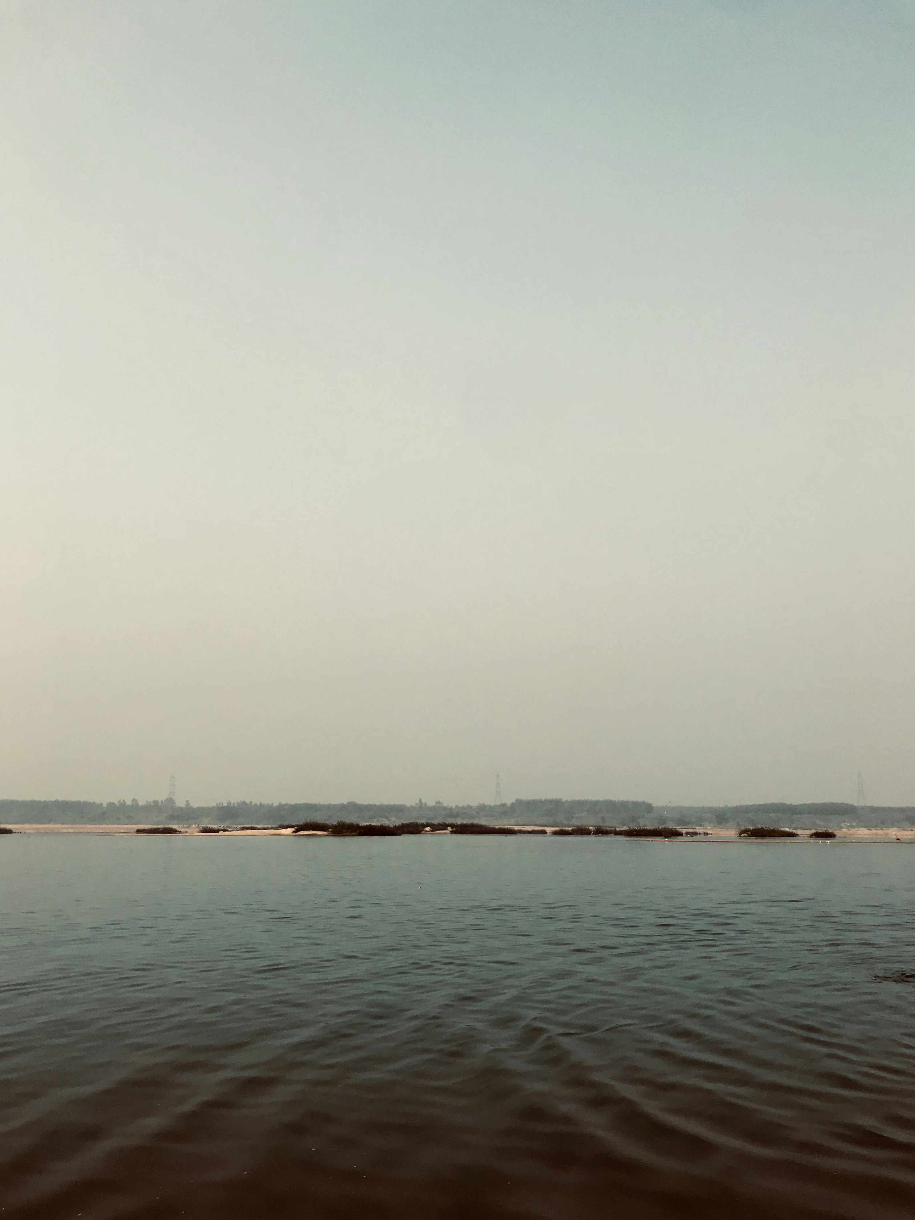 Serene pristine river water flowing. | body of water under white sky during daytime