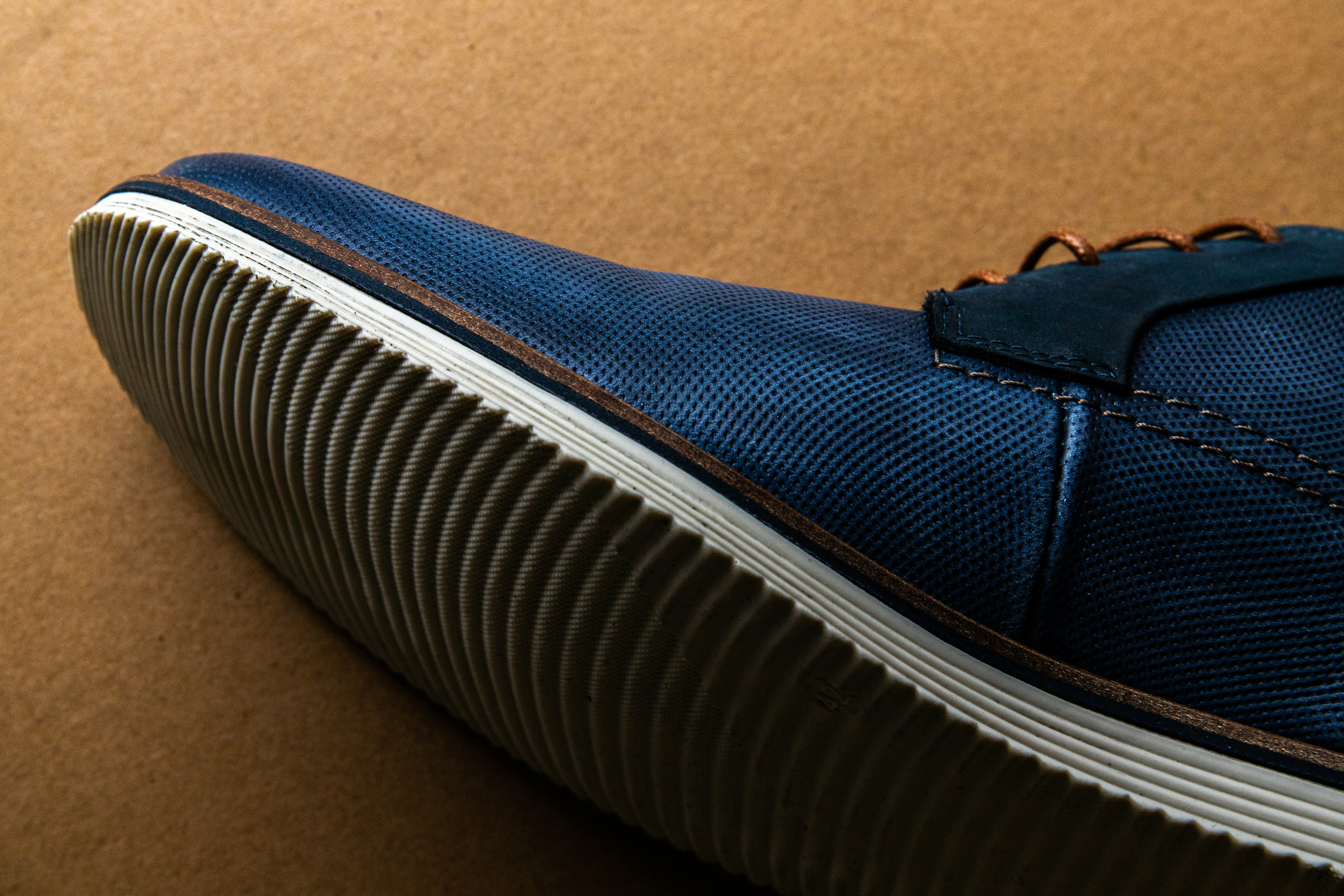 Blue sneaker edge: texture and linework on a cork backdrop