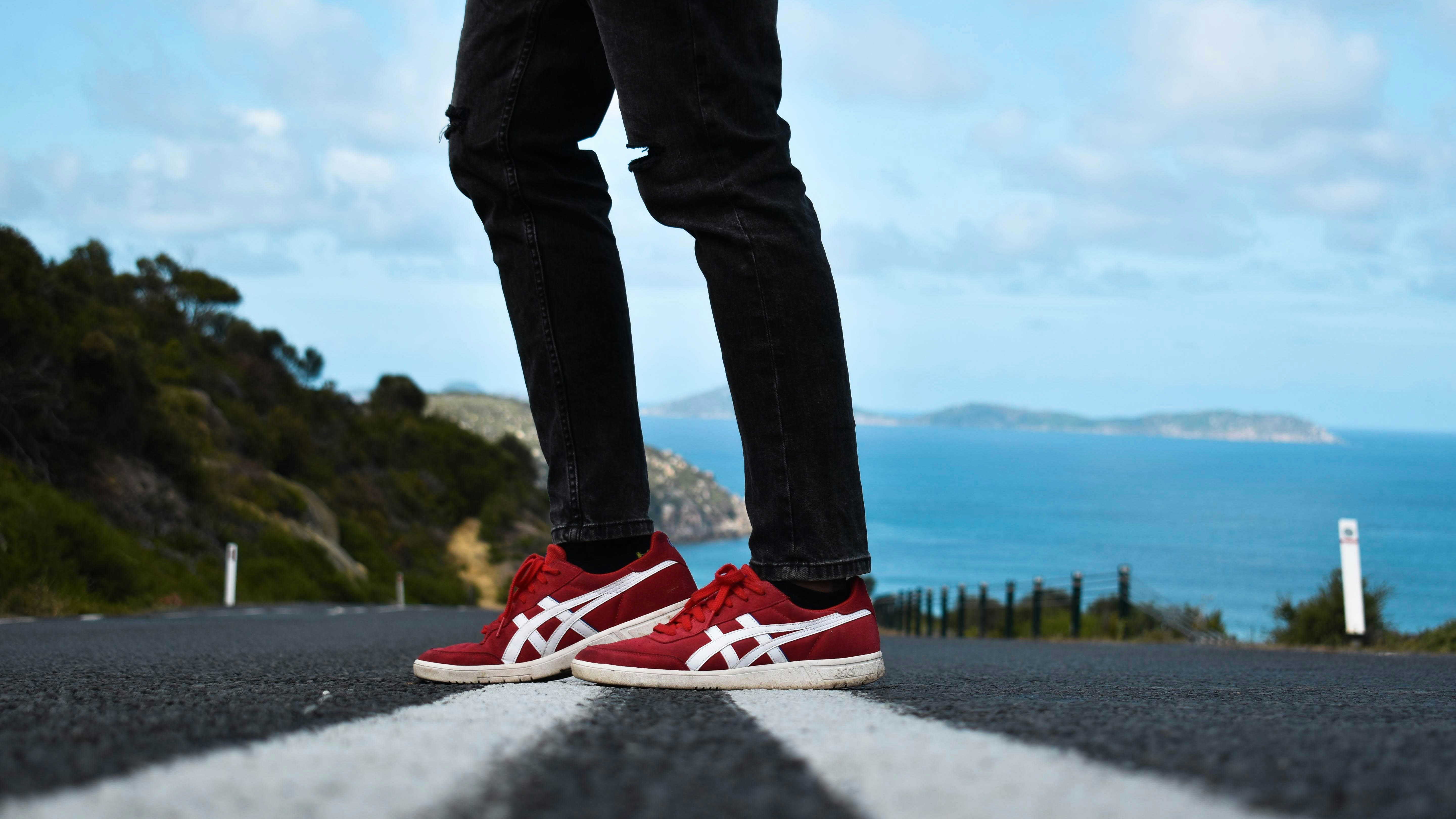 Low-Angle Moment: Red Sneakers Grounding the Coastal Road