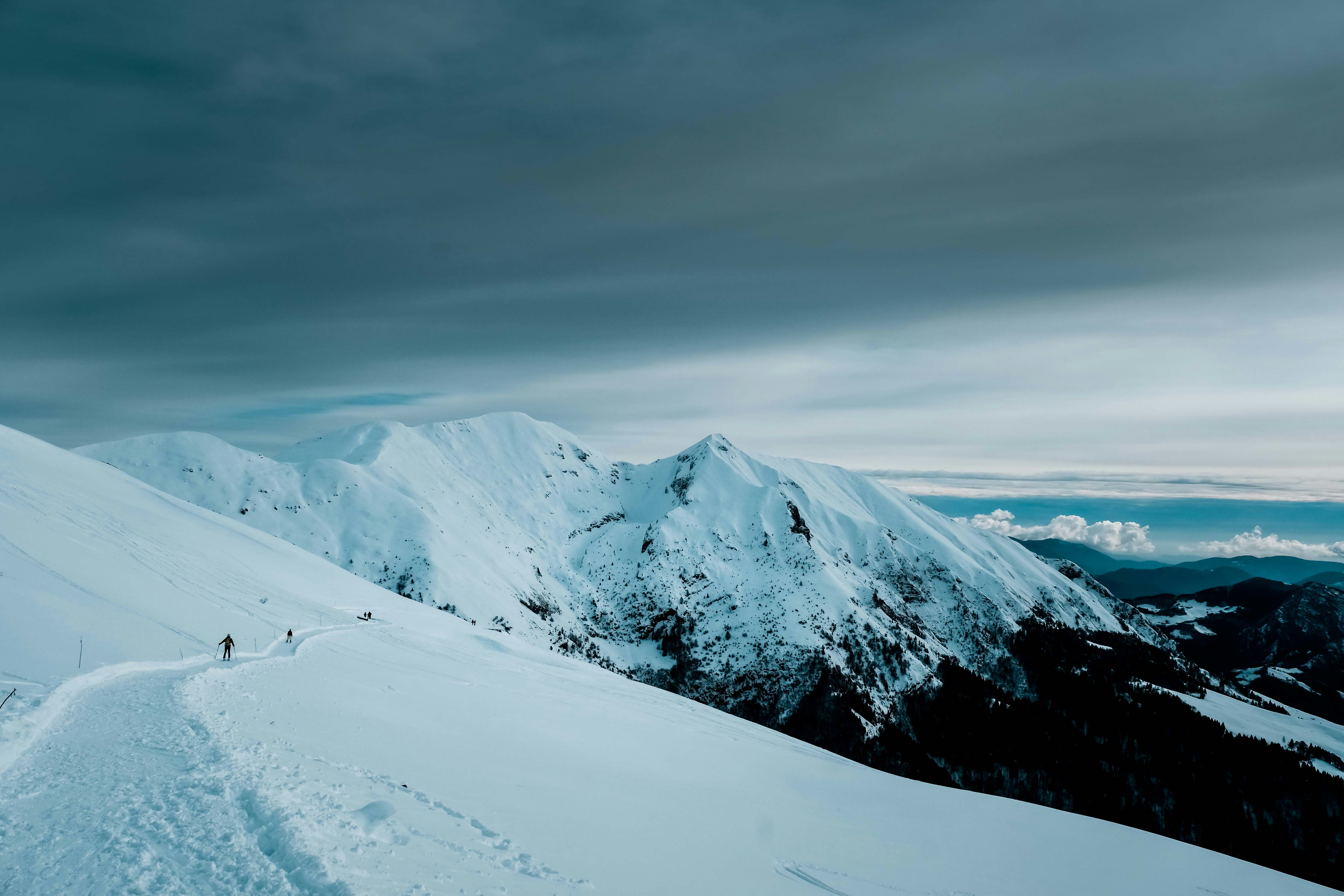 Snow covered mountain under cloudy sky during daytime photo – Free ...