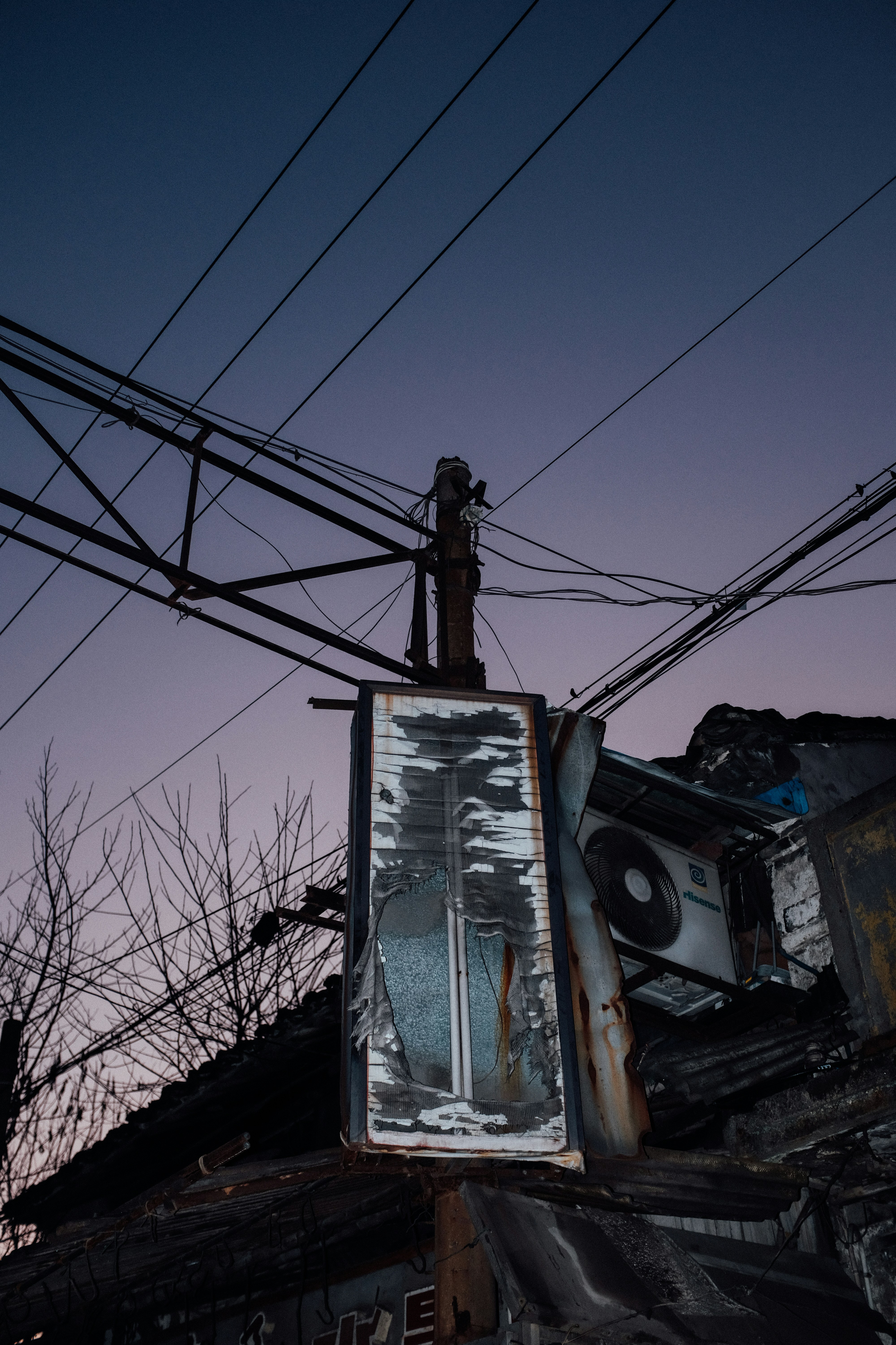 Twilight Tangle: A Rusted Street Sign Entwined by Power Lines