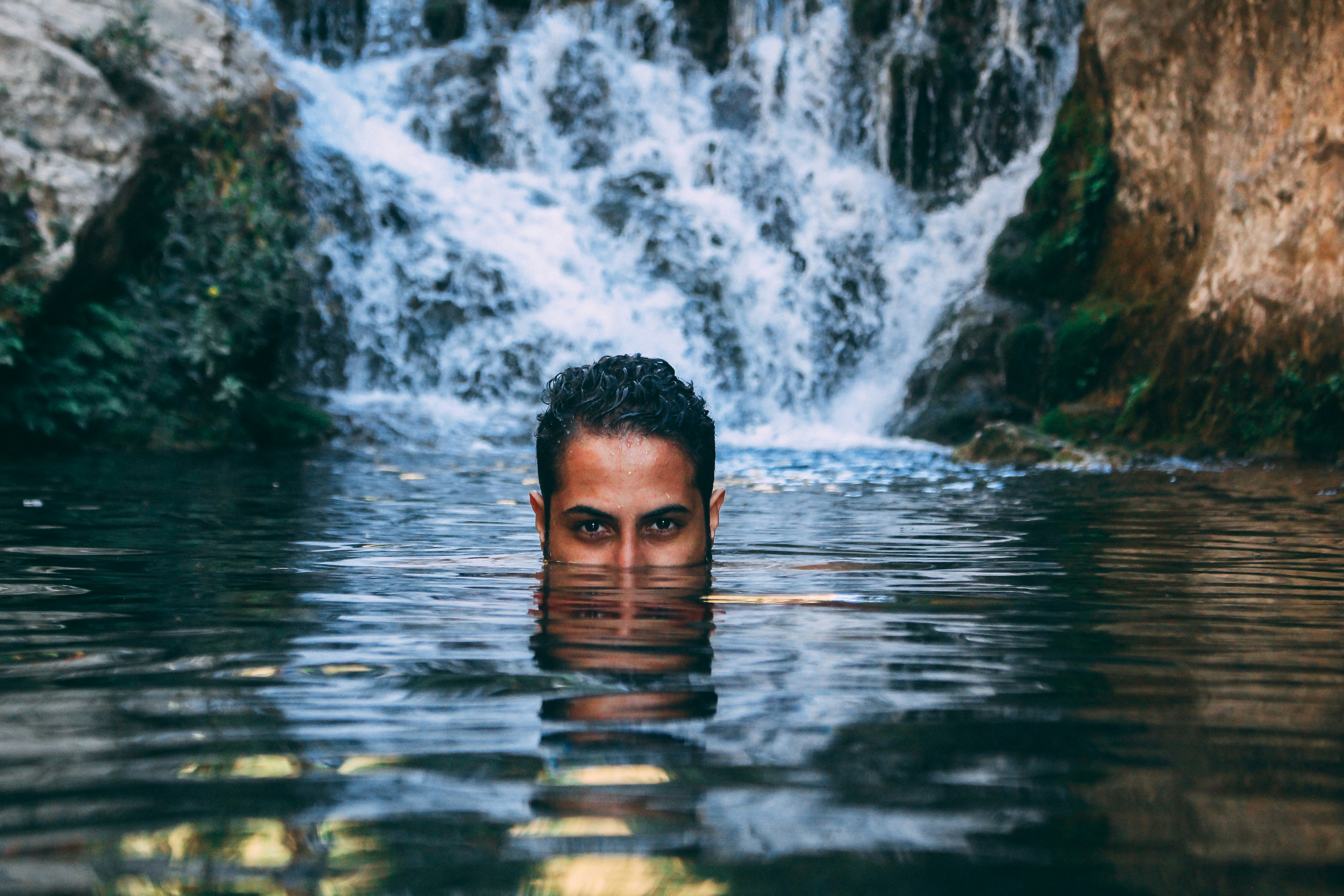 Eyes Above the Water: Portrait Quietly Emerges from a Cascade