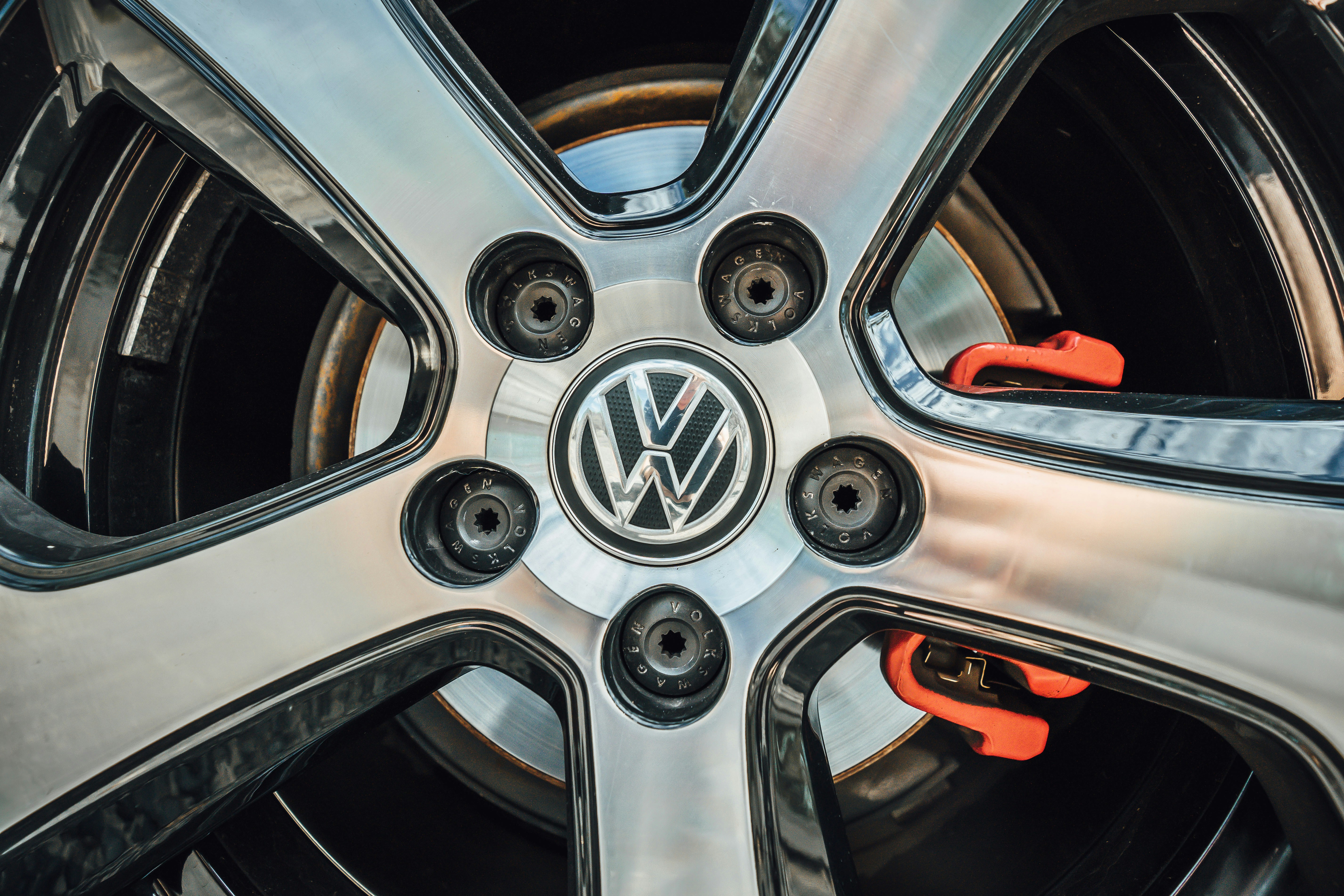 Chrome-Spoked Volkswagen Wheel Close-Up with Orange Calipers