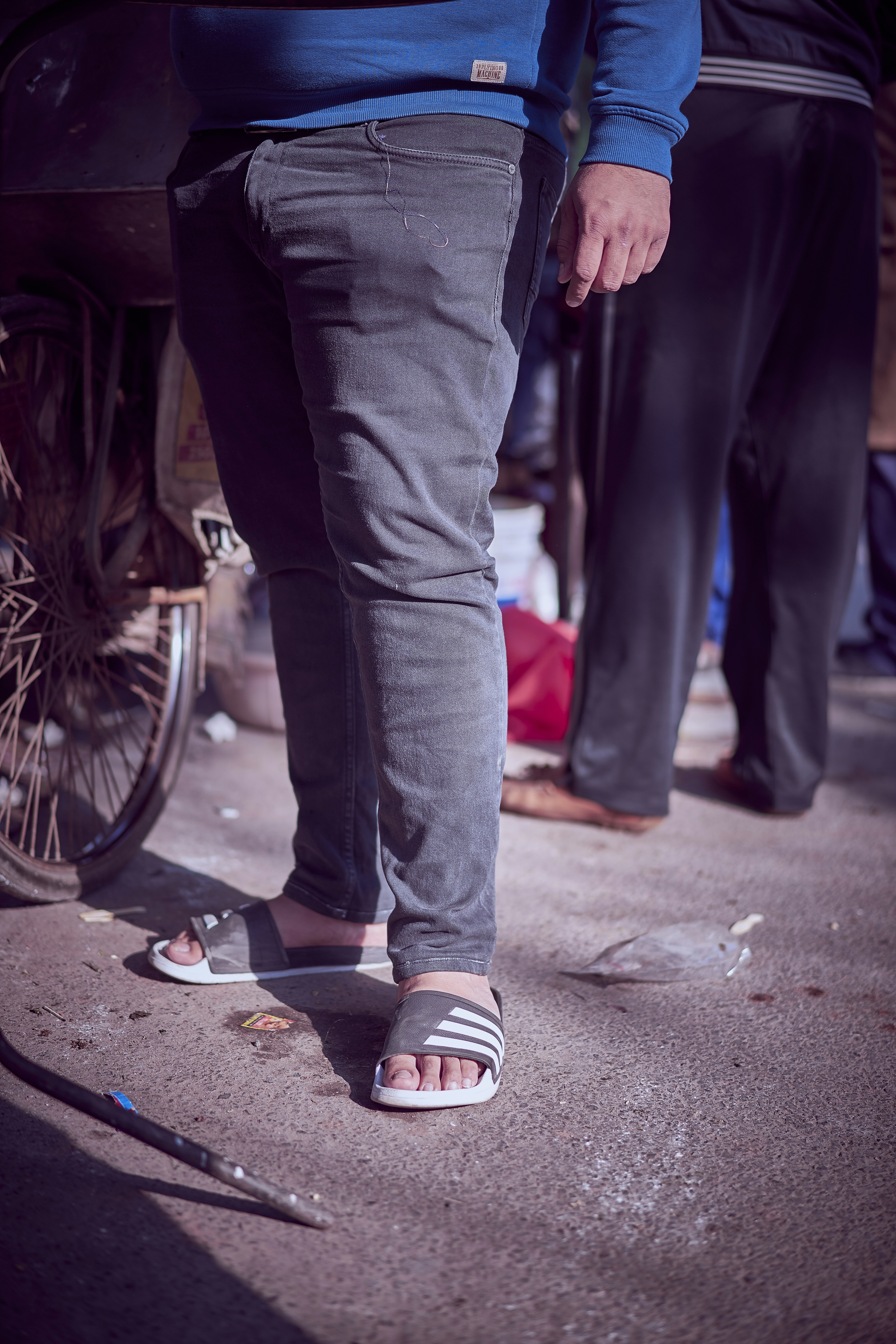 Man with Adidas slippers standing on road