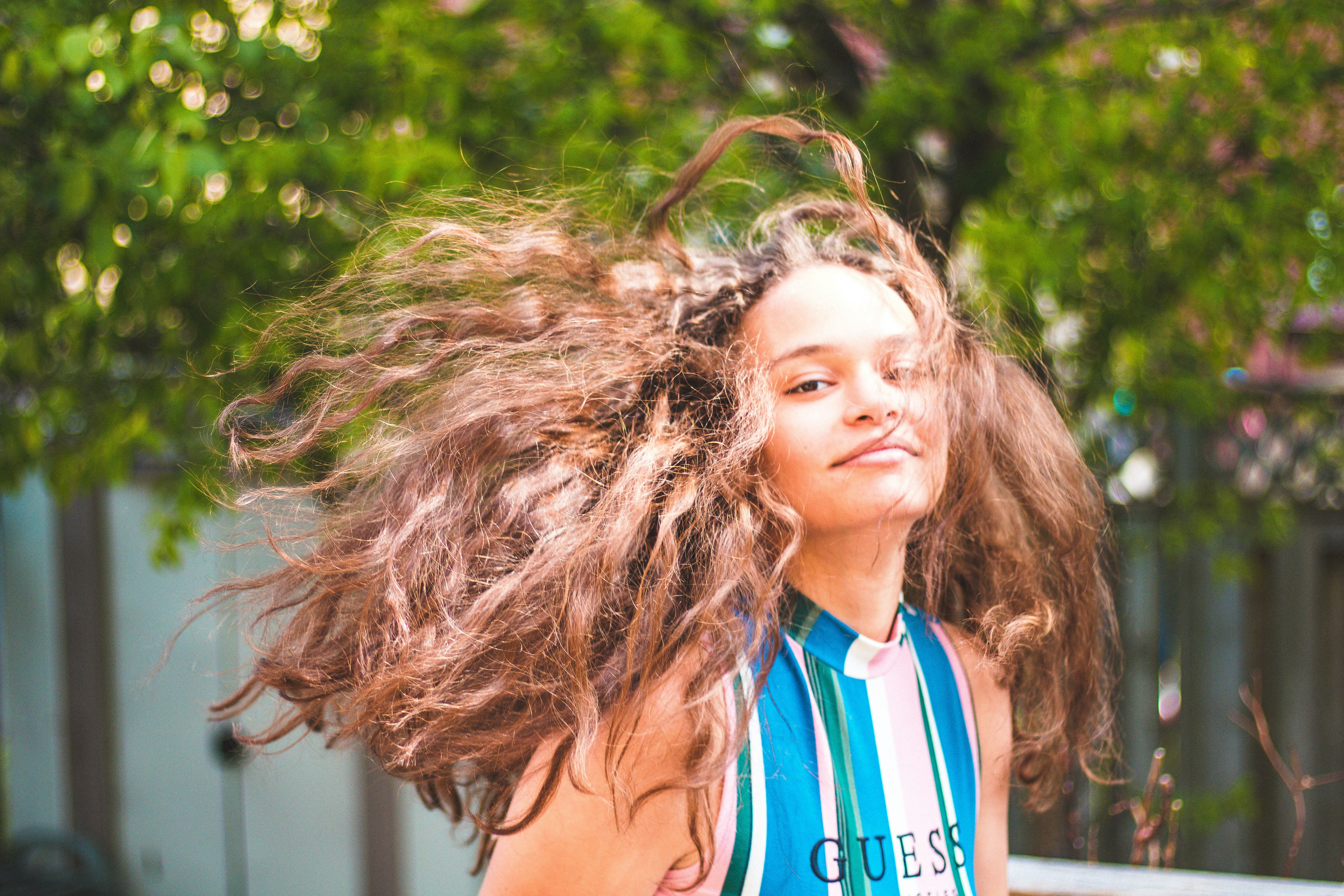 Hair in Motion: Portrait of a Youth in a Striped GUESS Tee
